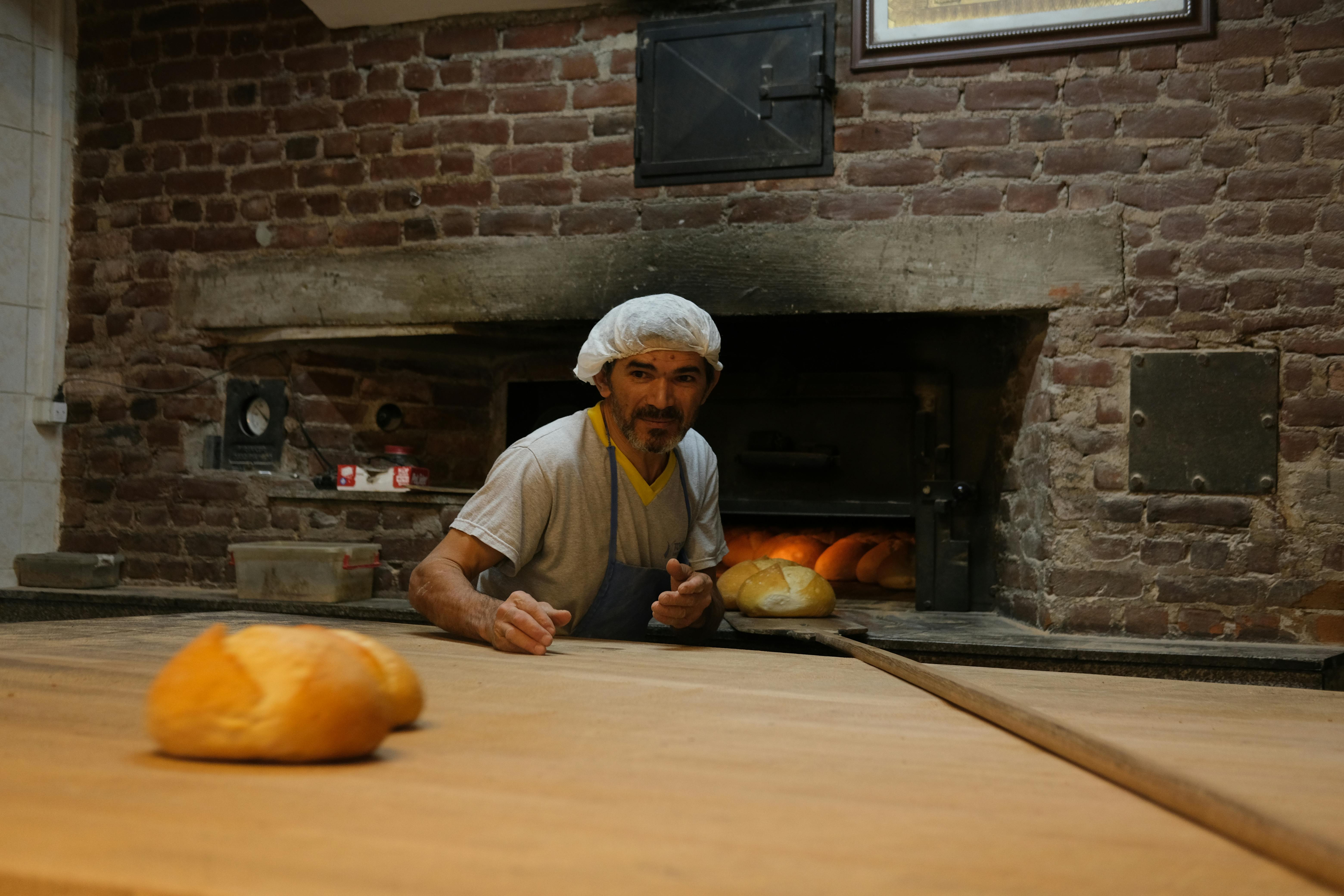 Traditional Baker at Work in Rustic Bakery · Free Stock Photo