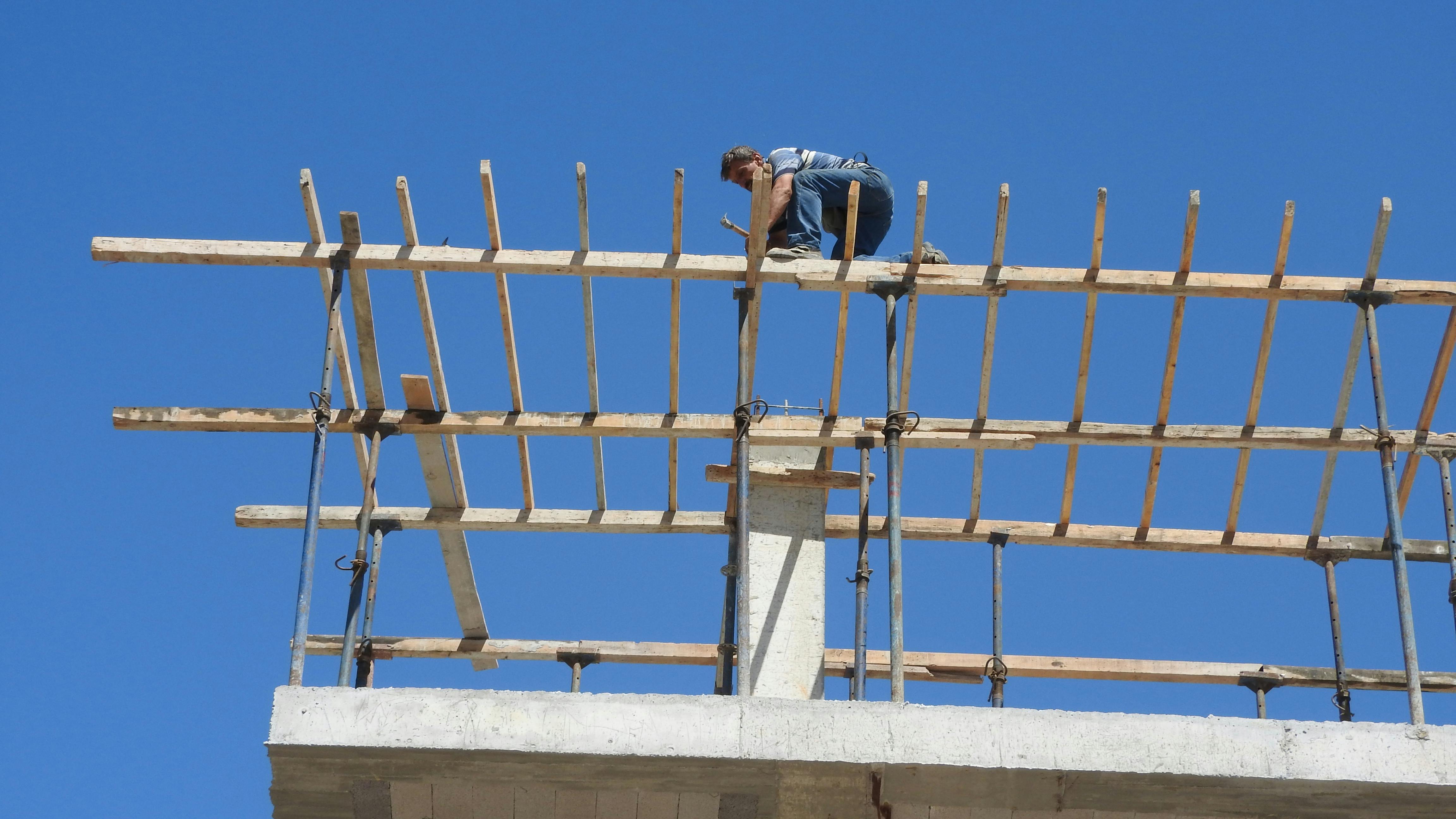 Construction Worker Balancing on Scaffolding · Free Stock Photo