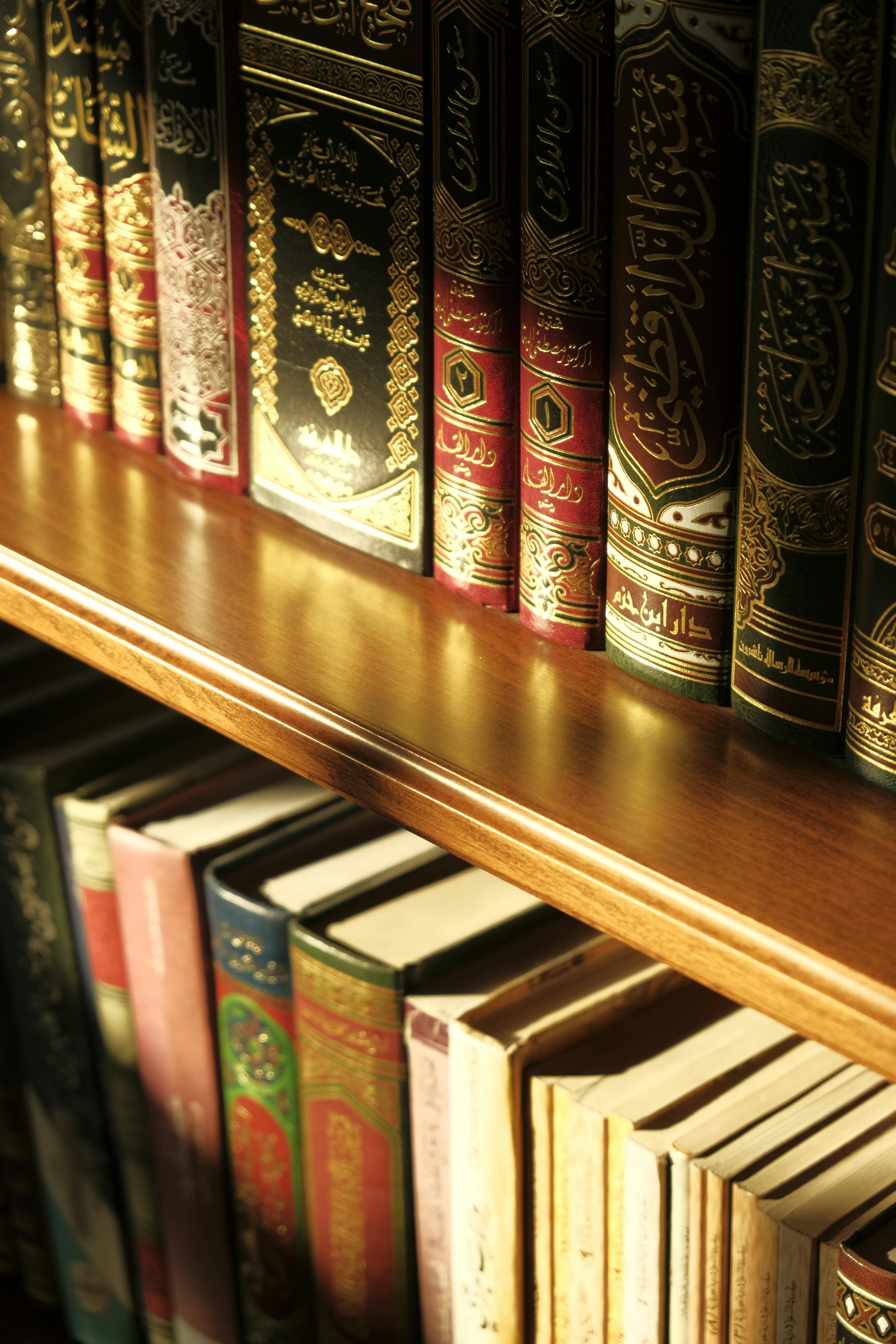 Ornate Religious Texts on a Bookshelf in Sunlight · Free Stock Photo