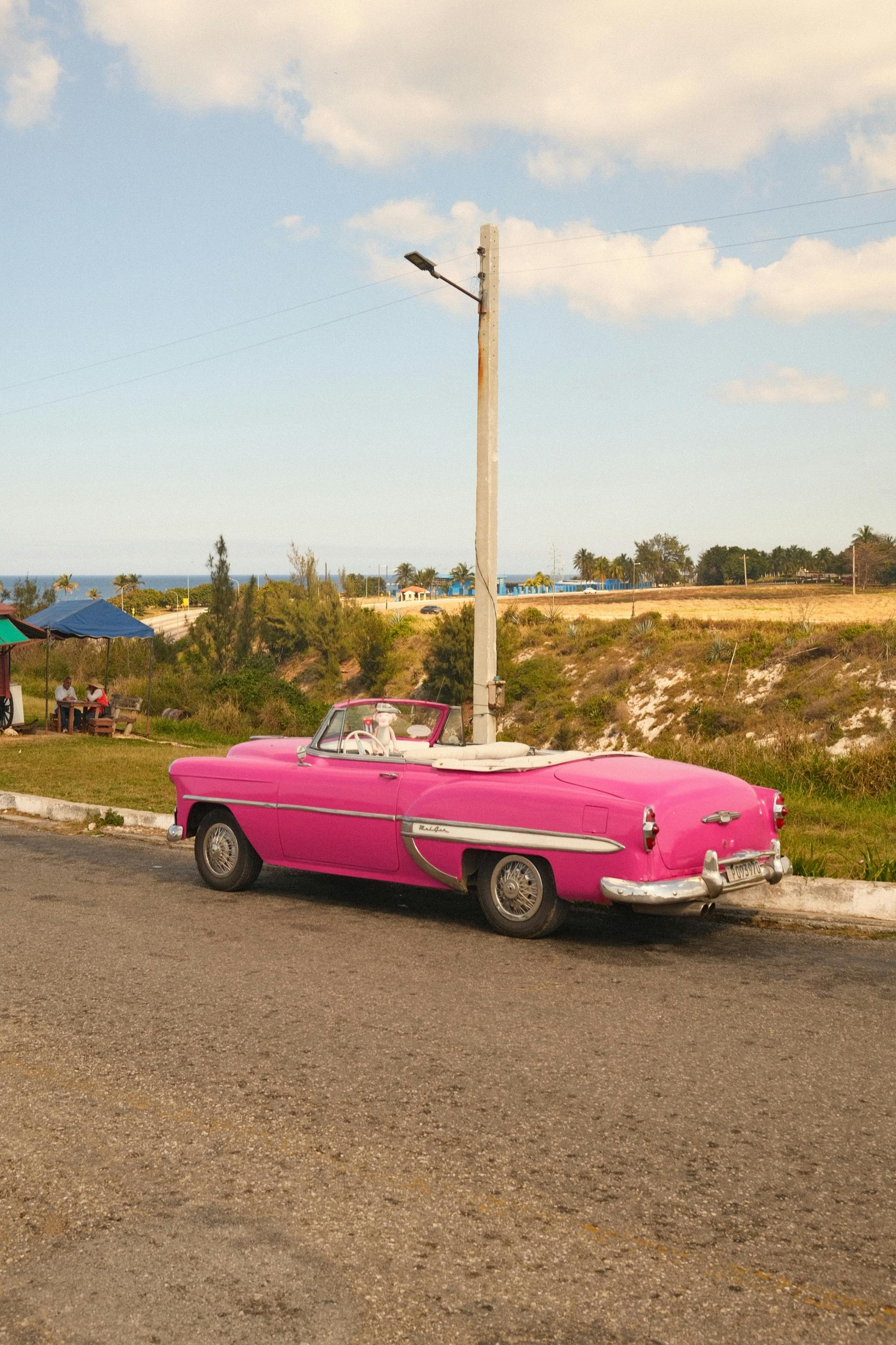 Vintage Pink Convertible on Scenic Coastal Road · Free Stock Photo