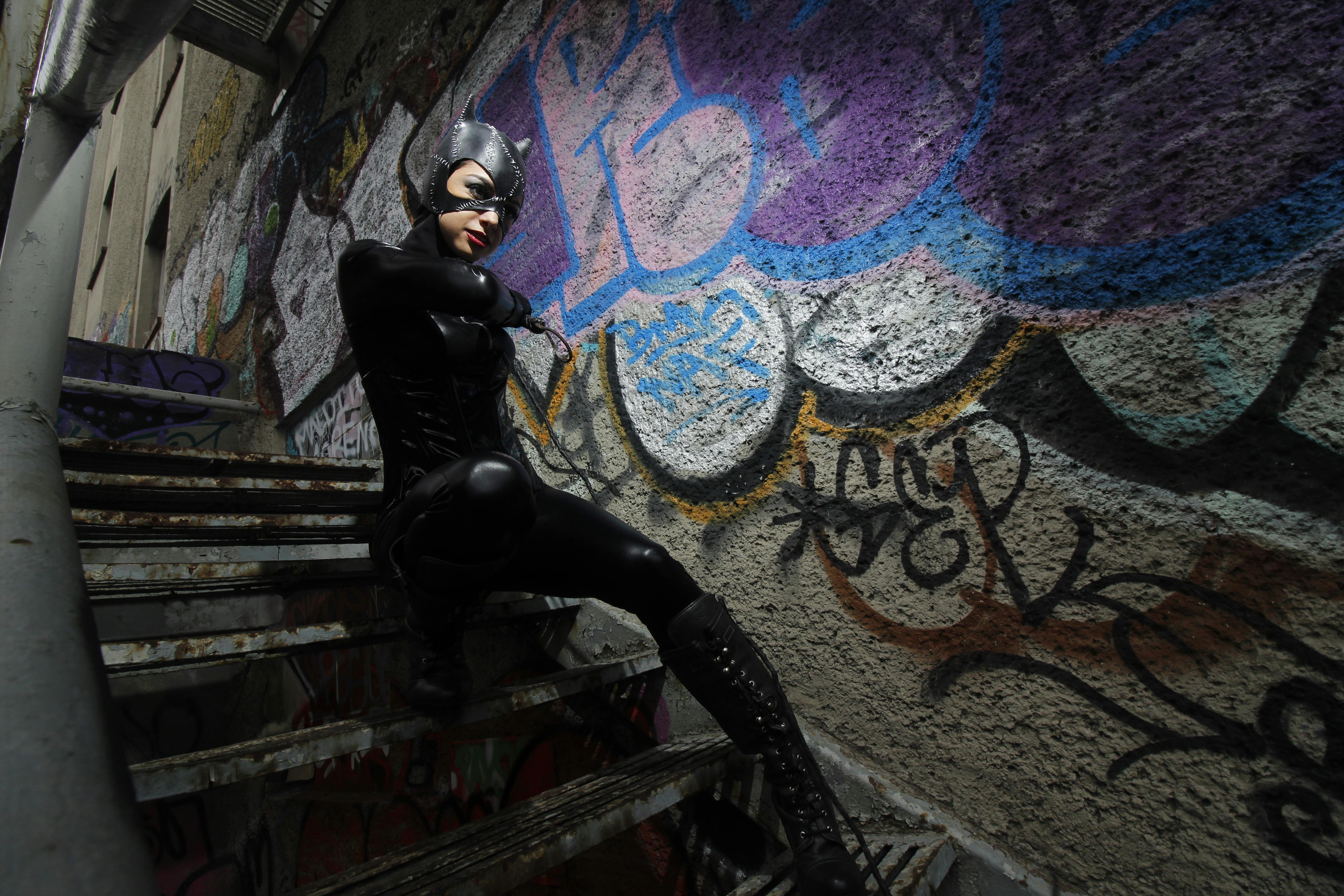 Cosplayer in Black Latex Costume Against Graffiti Wall · Free Stock Photo