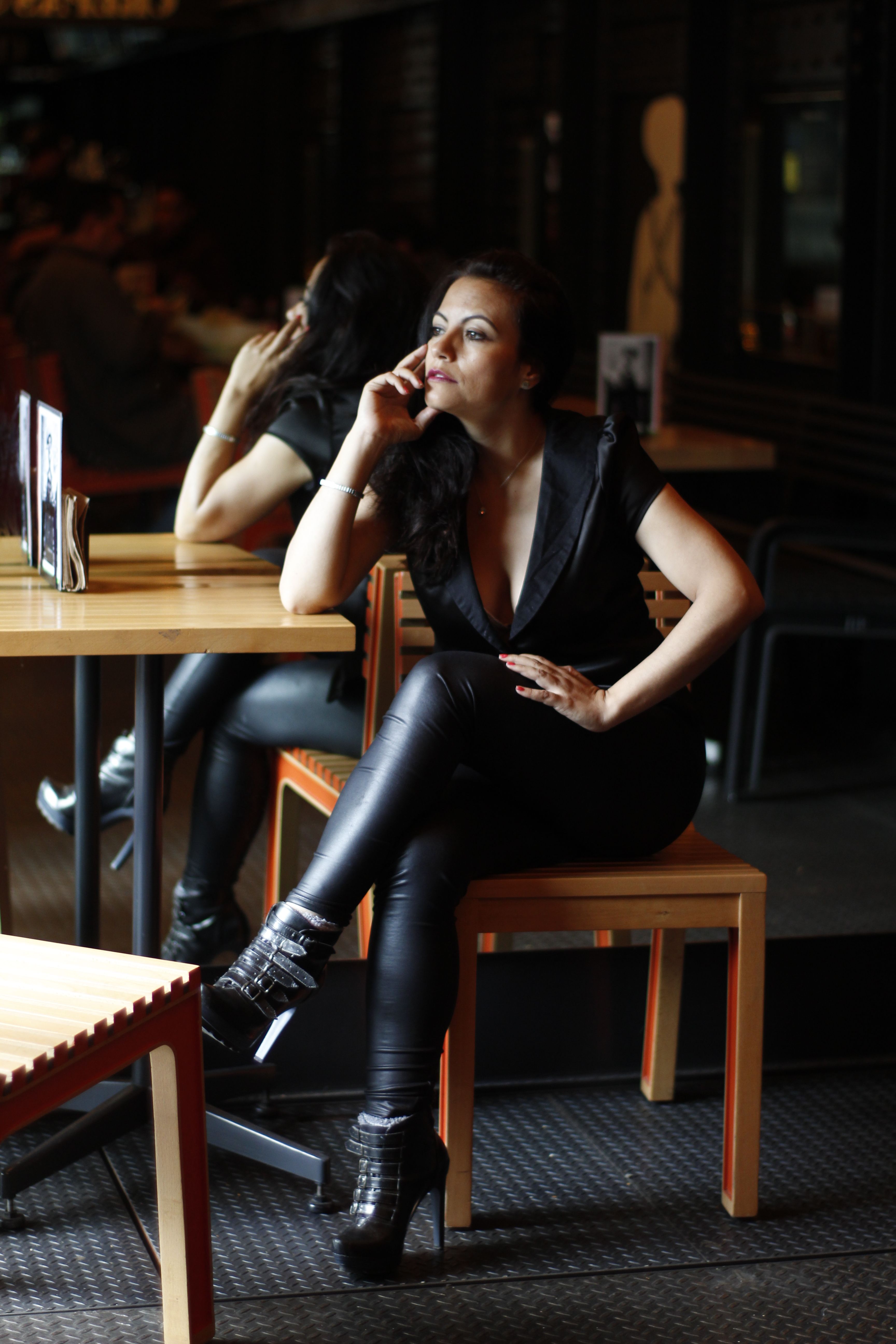 Elegant Woman in Reflective Pose at Café · Free Stock Photo