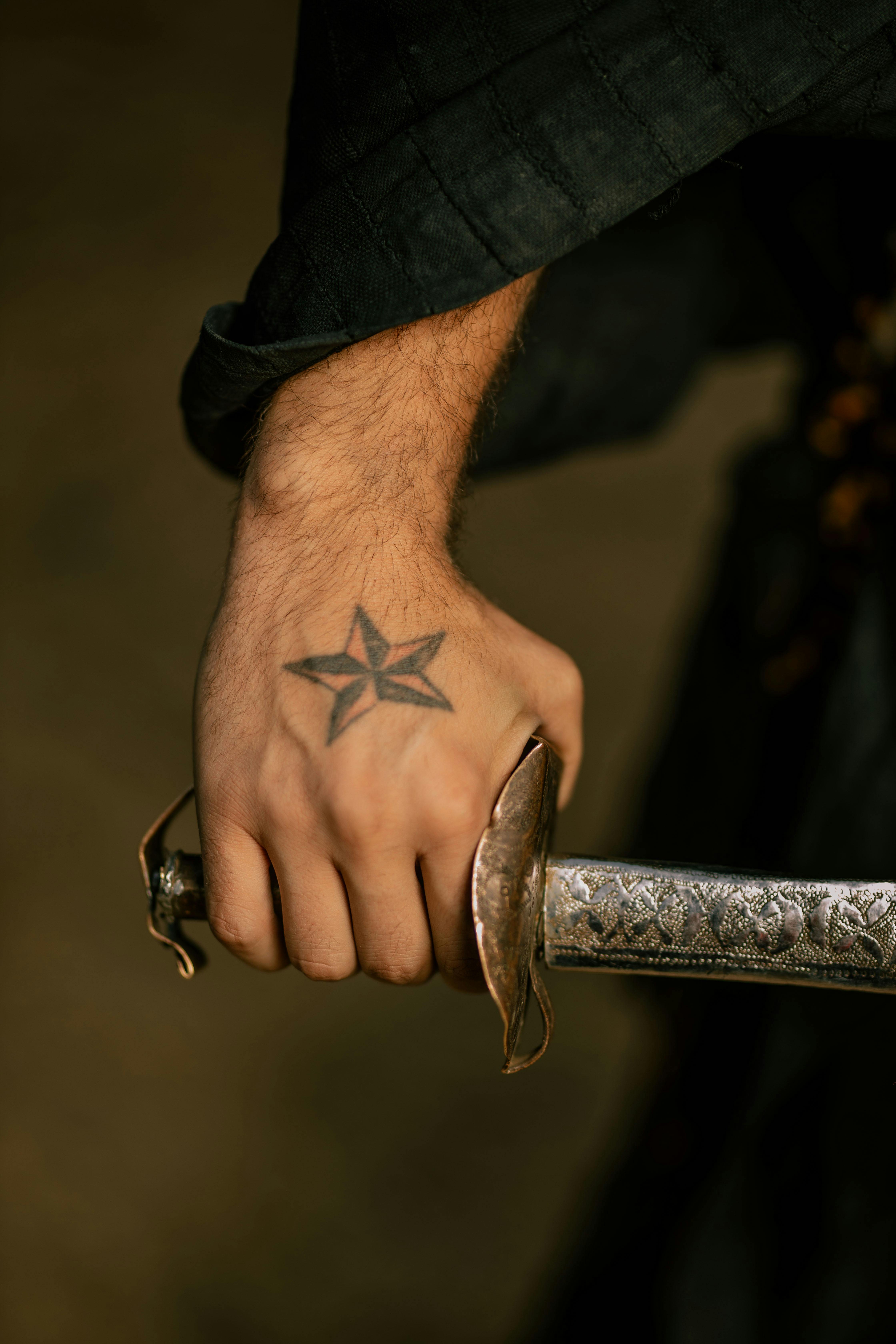 Close-up of Hand Holding a Decorative Sword · Free Stock Photo