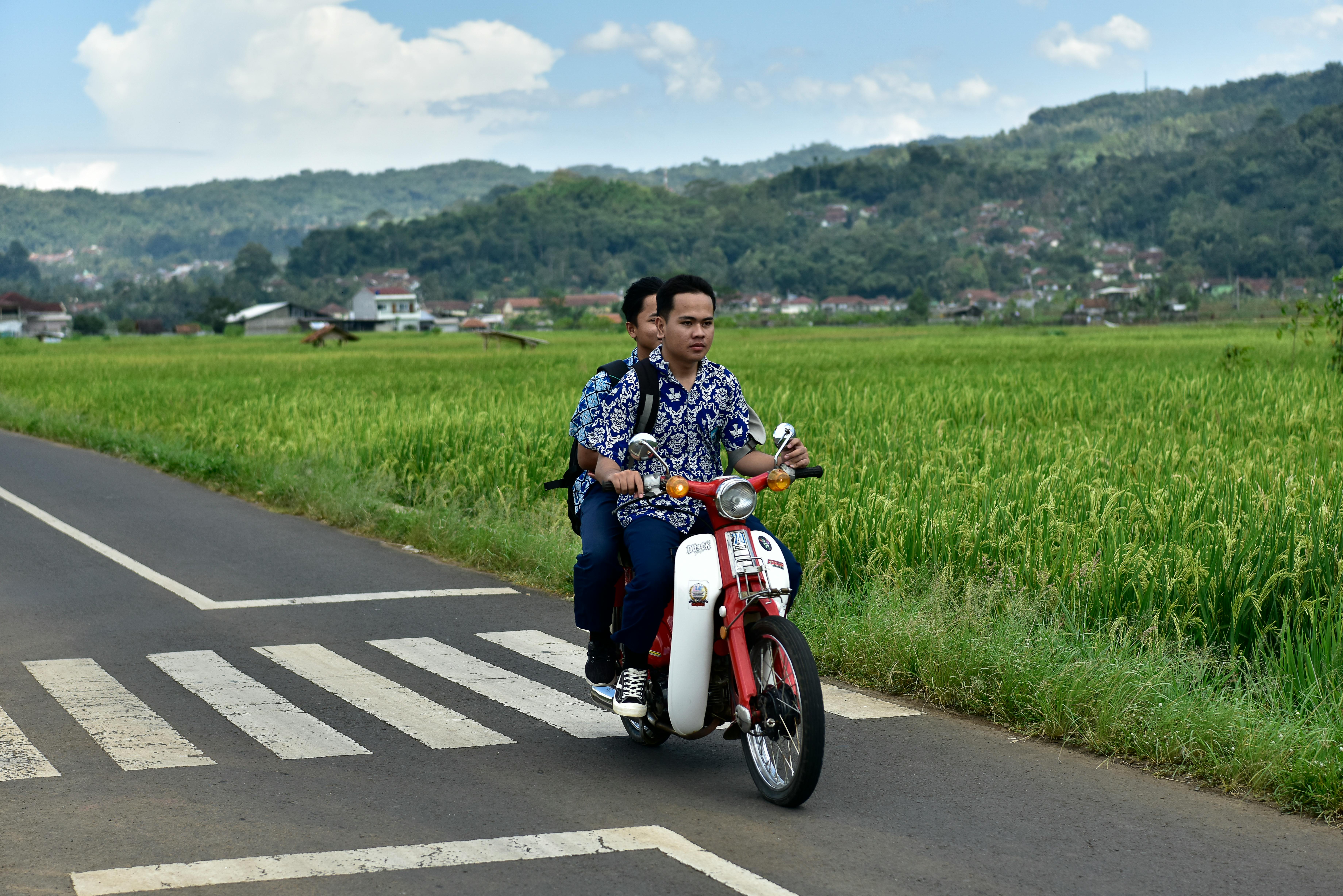 Two Men Riding Motorcycle on Rural Road · Free Stock Photo