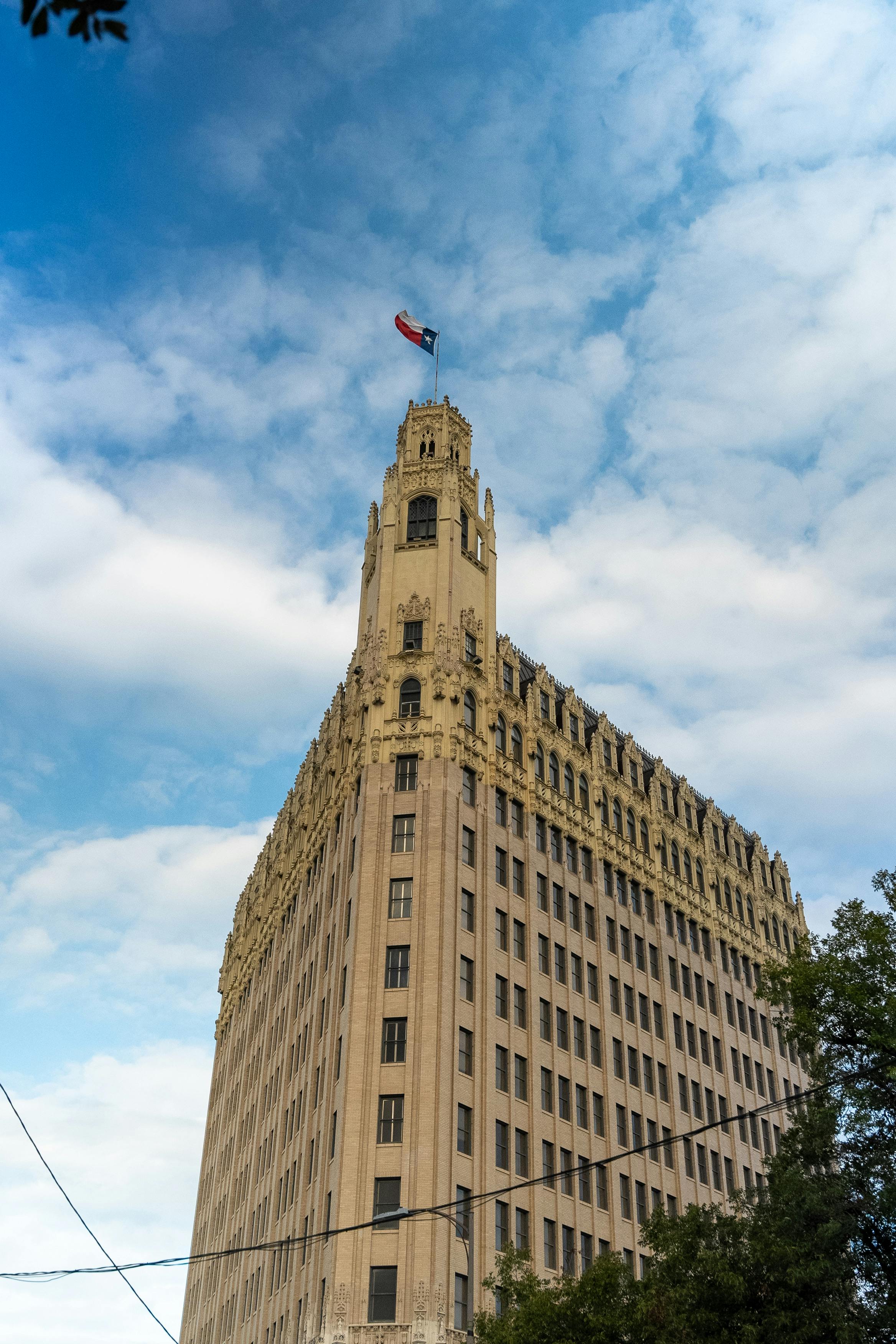 Historic High-Rise Building with Flag in Skyline · Free Stock Photo