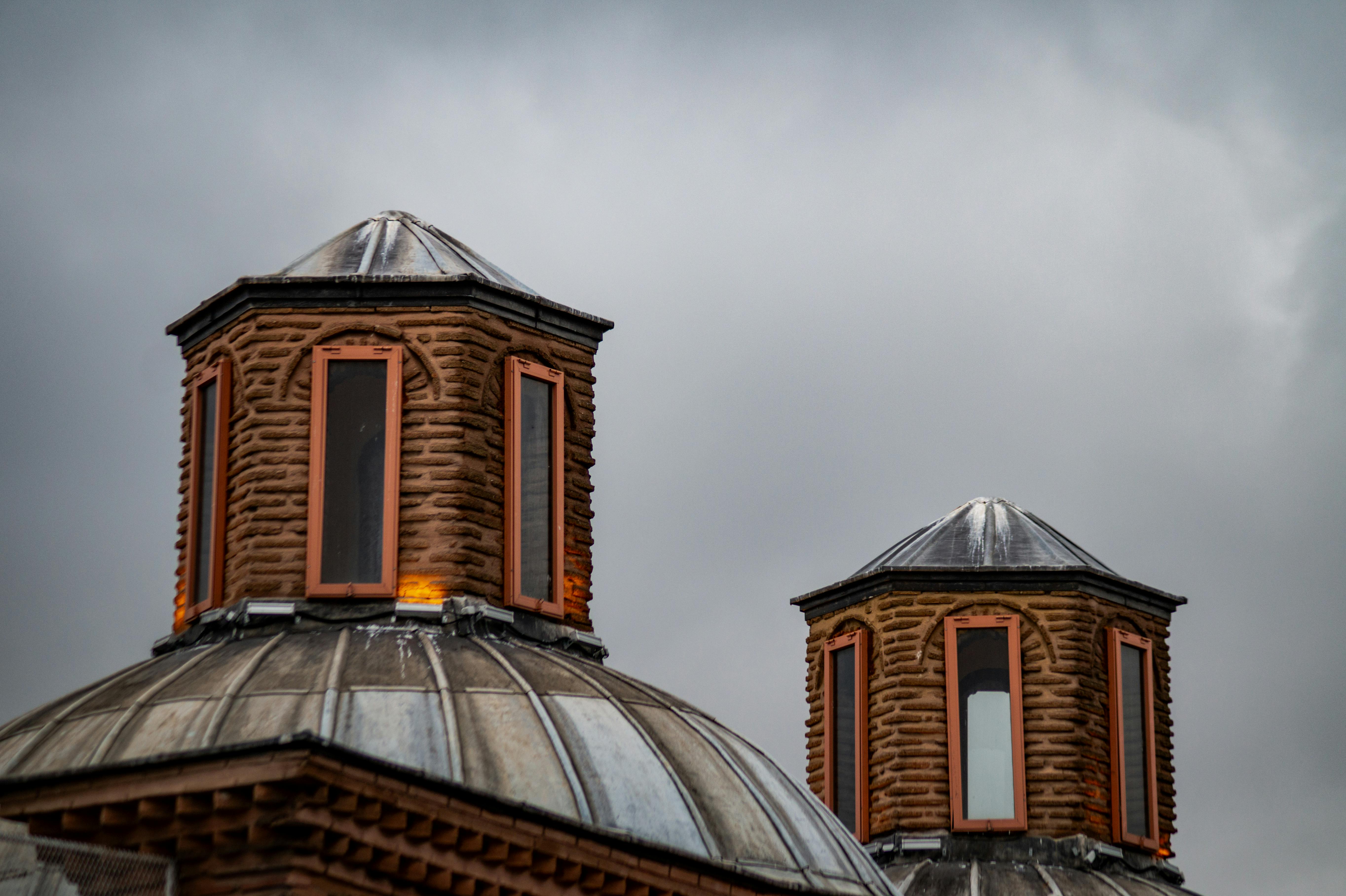 Historic Brick Roof Towers Against Overcast Sky · Free Stock Photo
