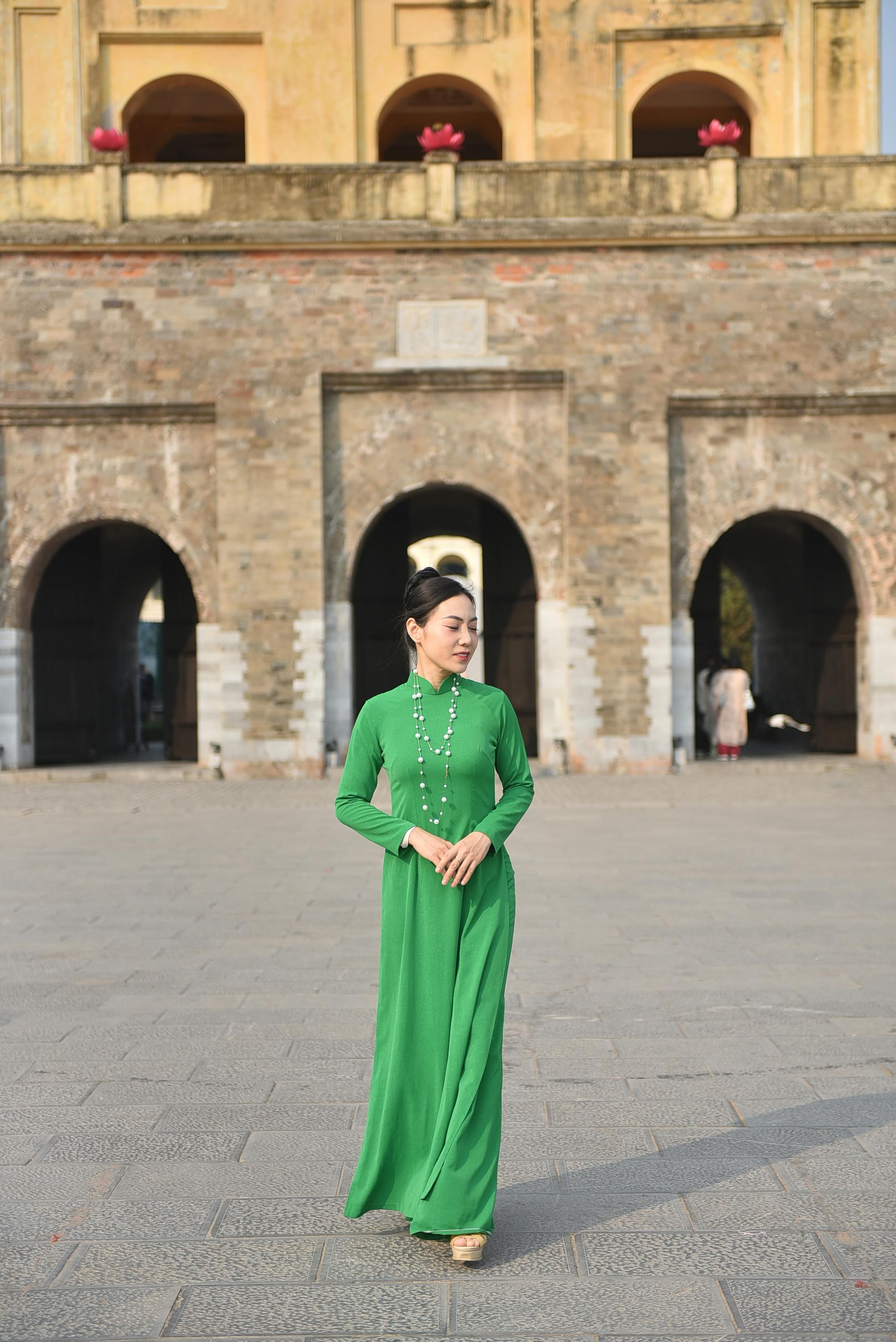 Woman in Traditional Green Dress at Ancient Gate · Free Stock Photo
