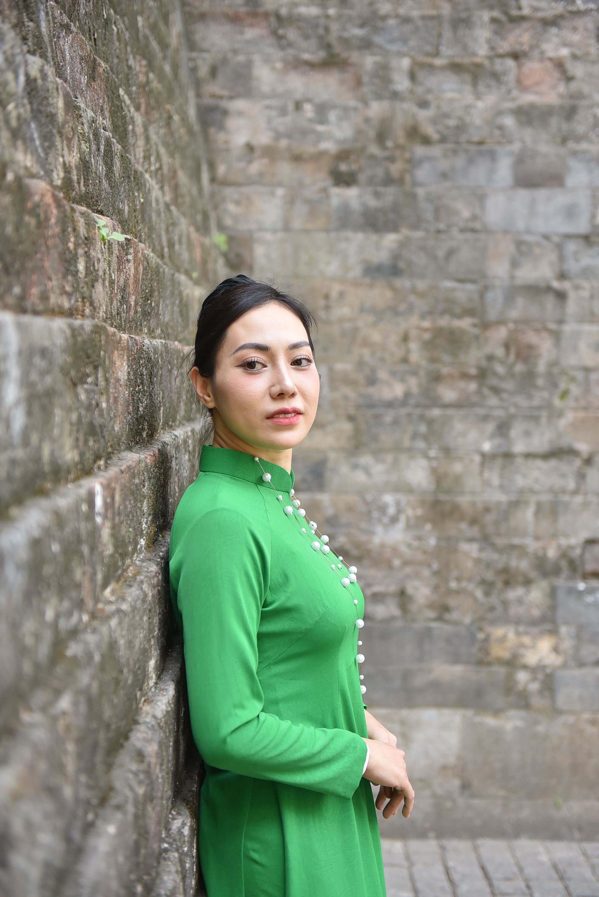 Woman in Green Traditional Dress by Stone Wall · Free Stock Photo