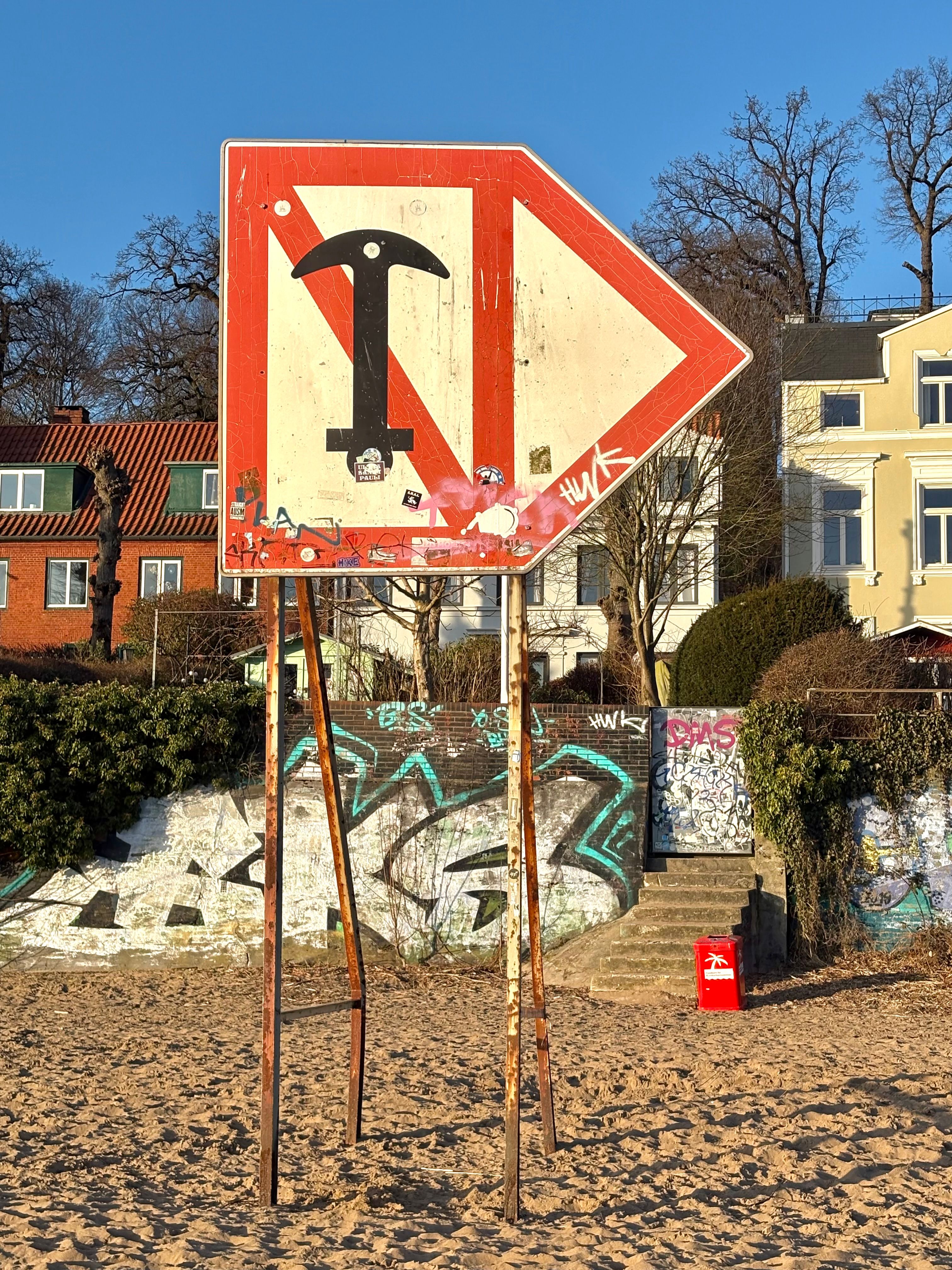 Graffiti-covered sign on sandy Hamburg beach · Free Stock Photo