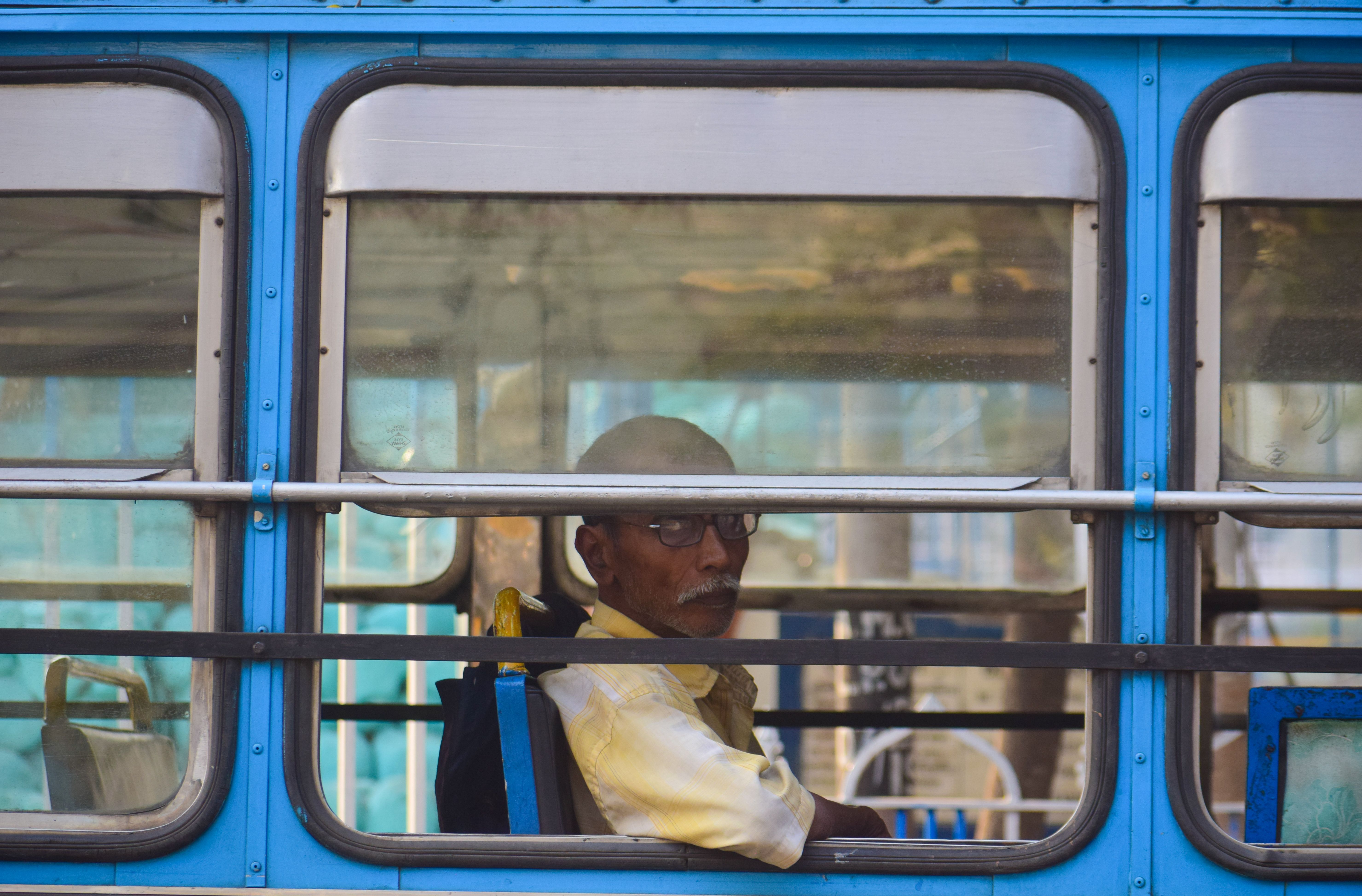 Man on a Kolkata Bus Observing the Street · Free Stock Photo