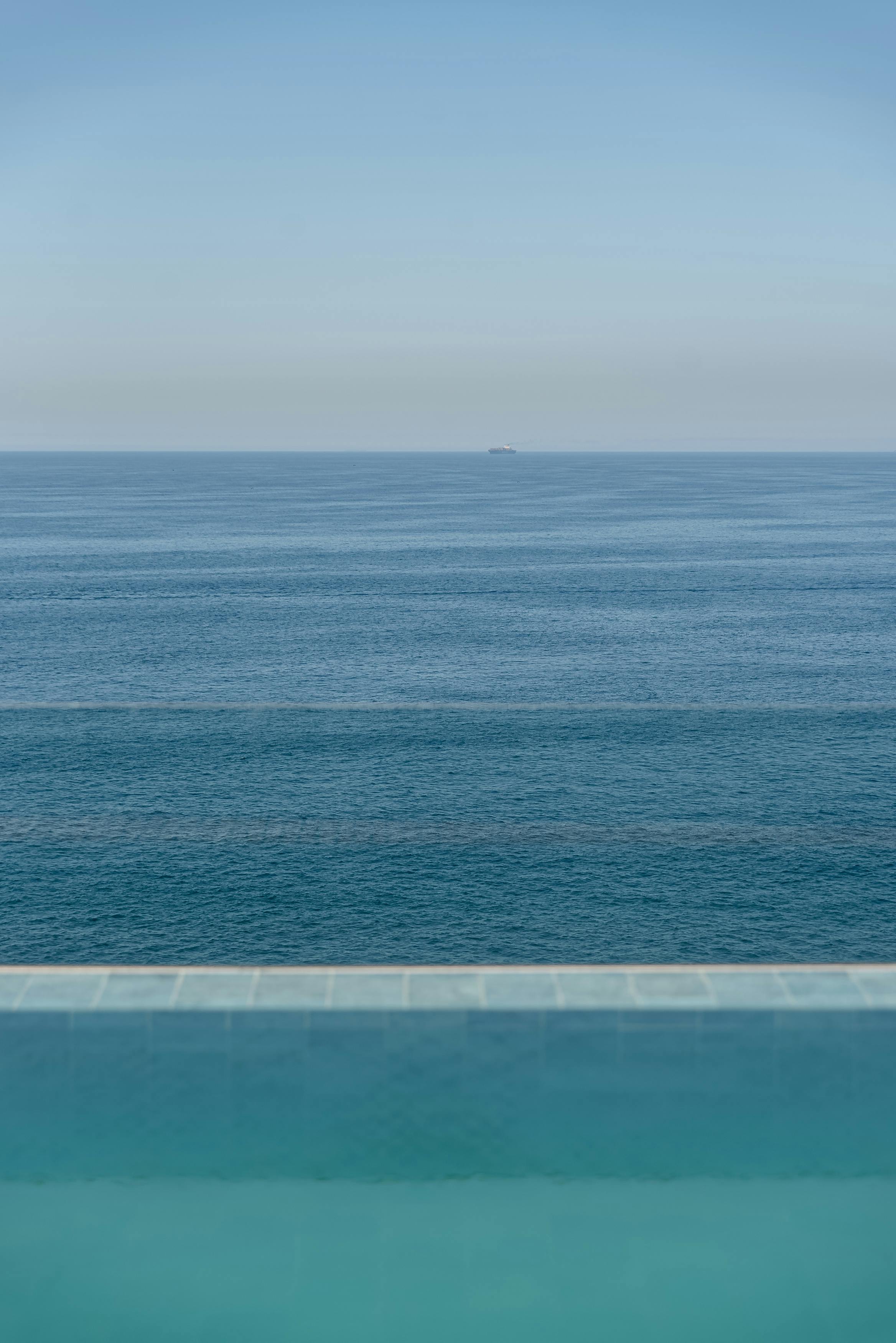 Serene Infinity Pool Overlooking Ocean Horizon · Free Stock Photo