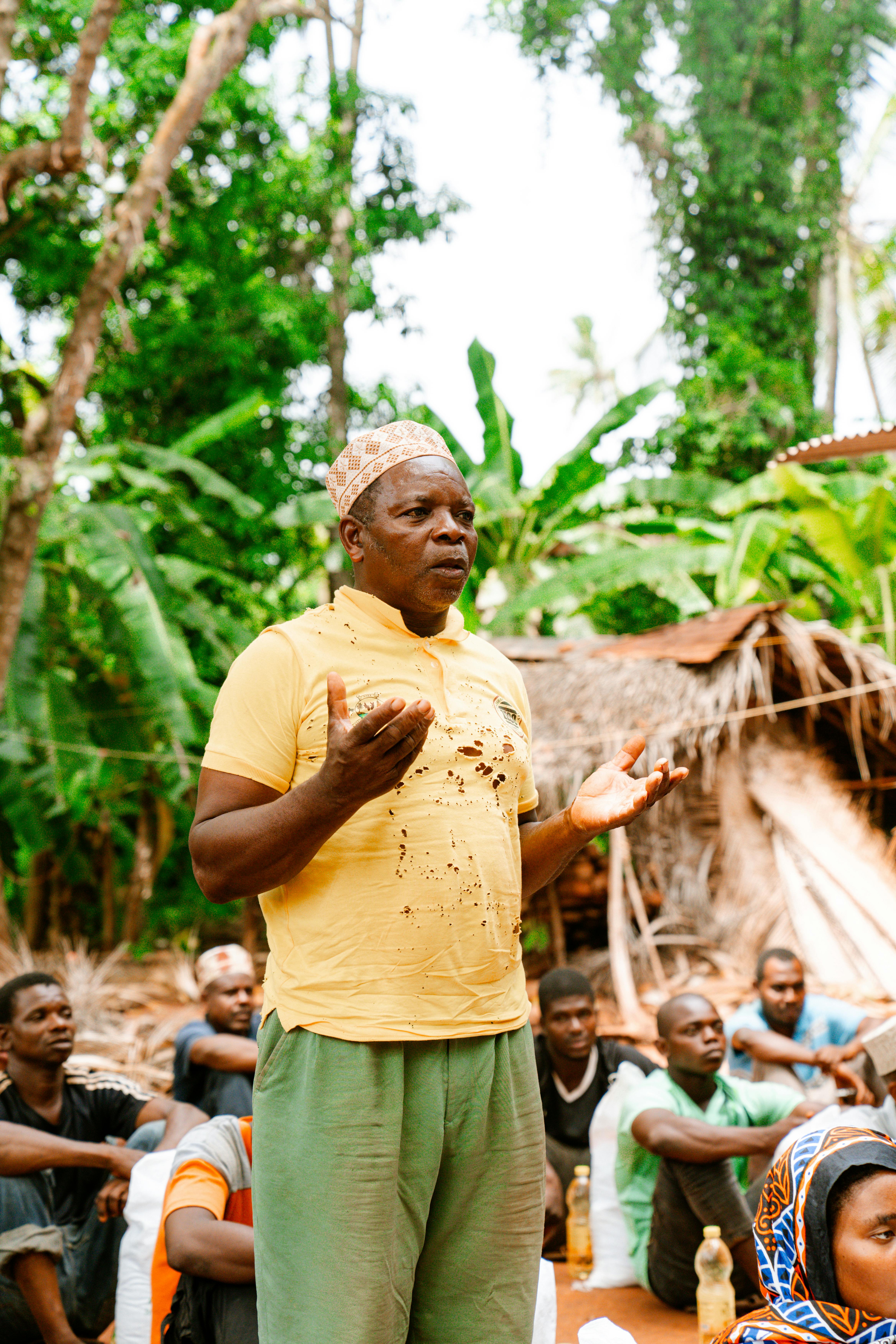 Man Leading Community Meeting in Tropical Village · Free Stock Photo