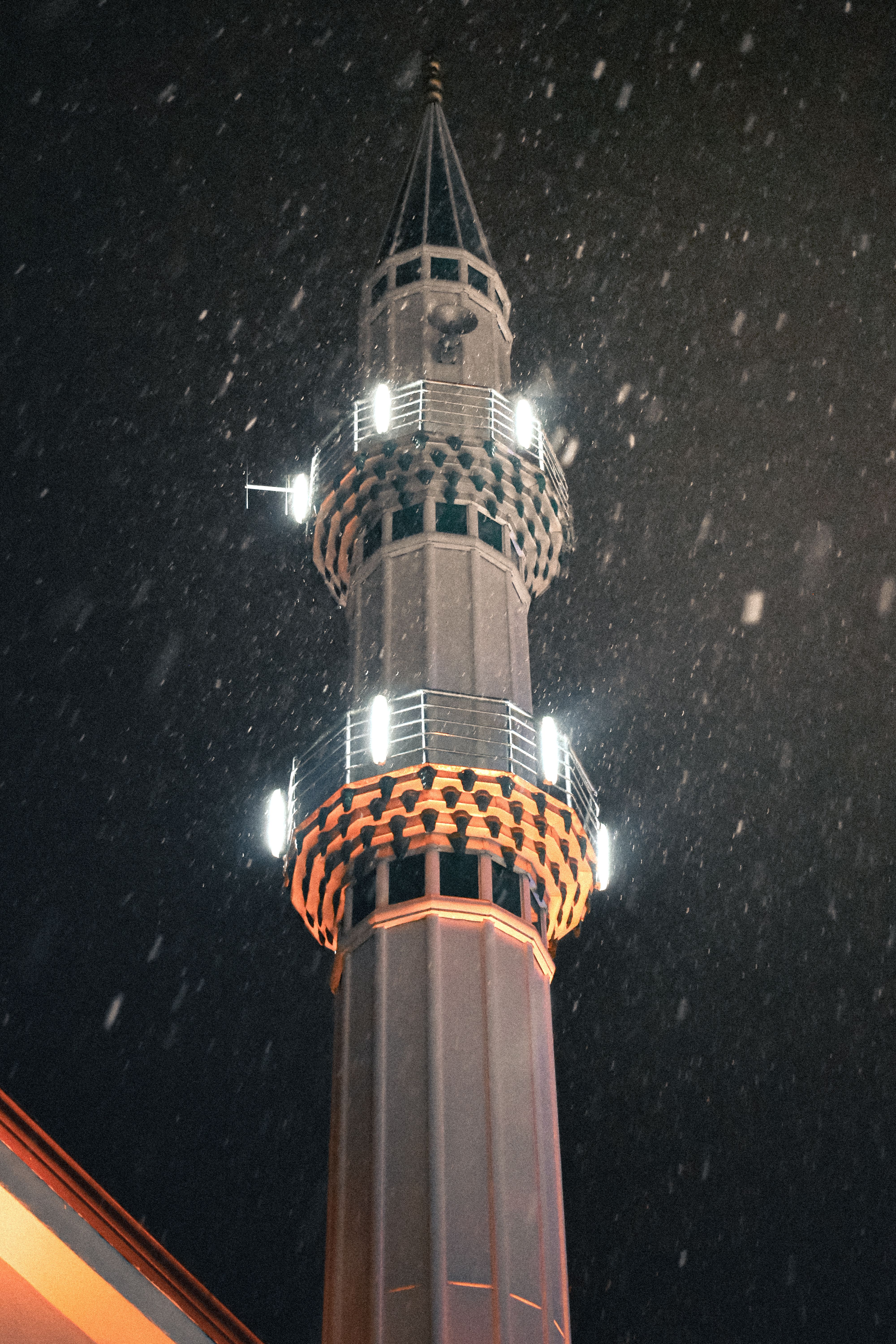 Illuminated Minaret in Snowy Nighttime Atmosphere · Free Stock Photo