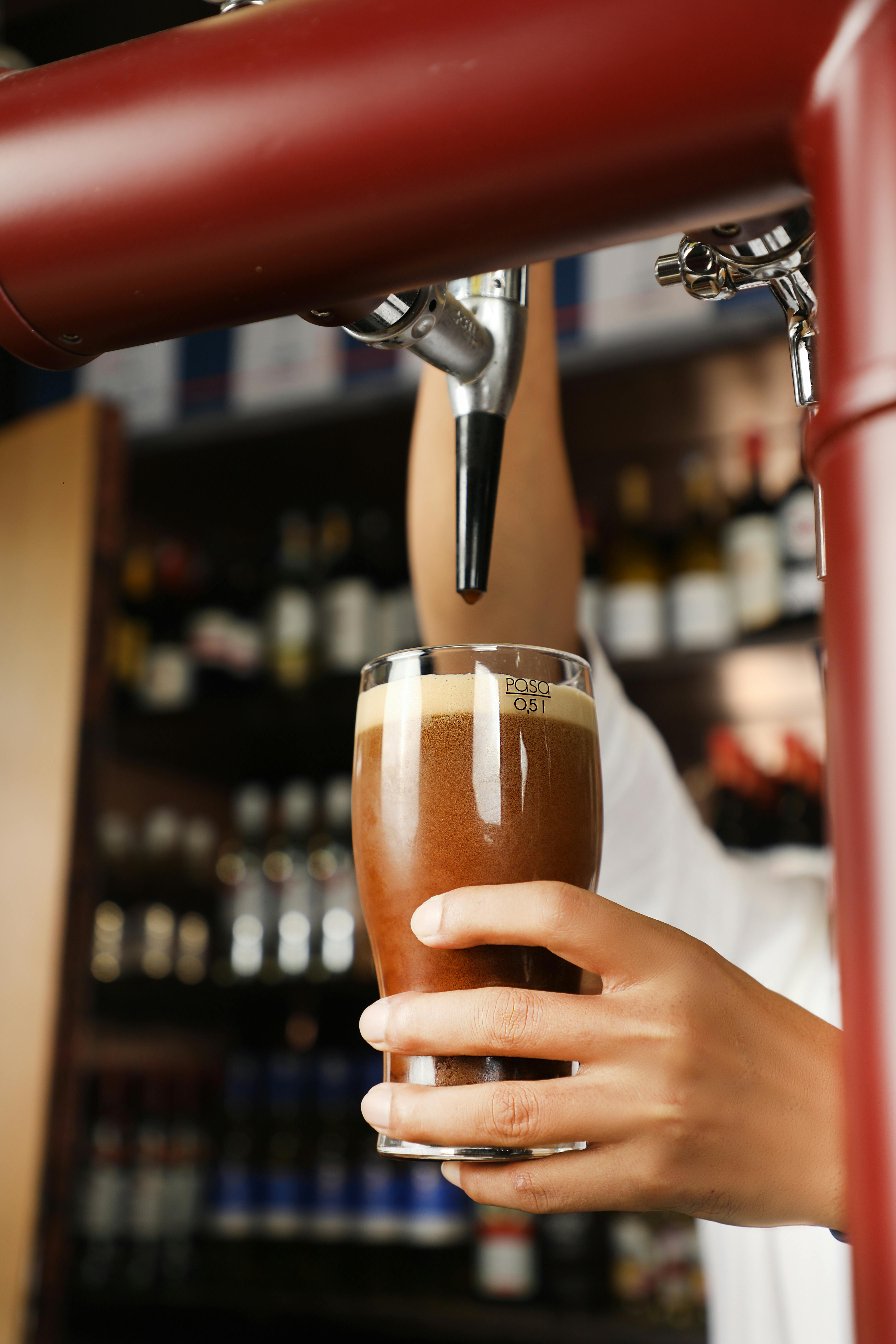Hand Pouring Draft Beer at a Bar · Free Stock Photo