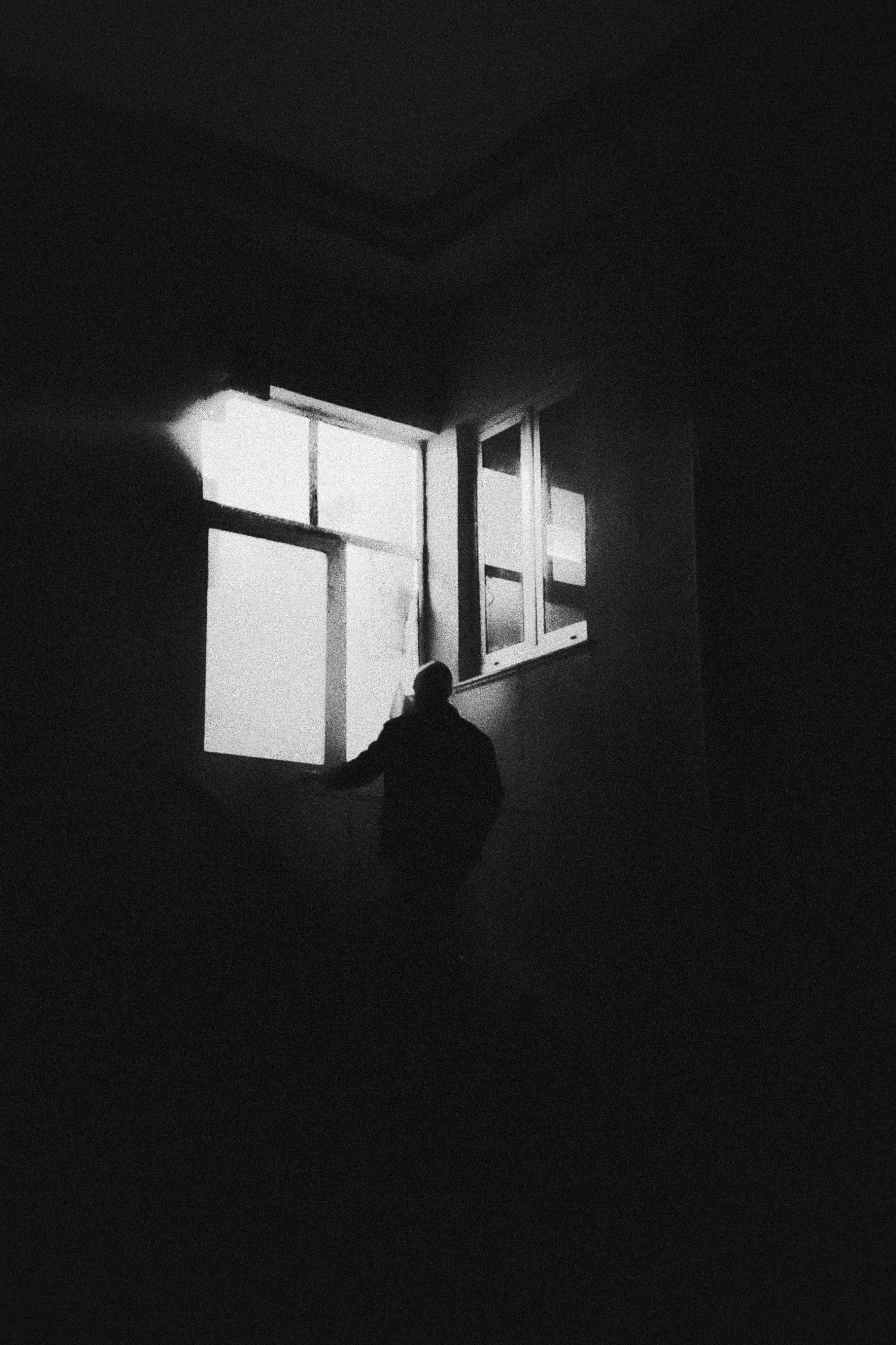 Silhouette of Person Standing by Window in Dark Room · Free Stock Photo