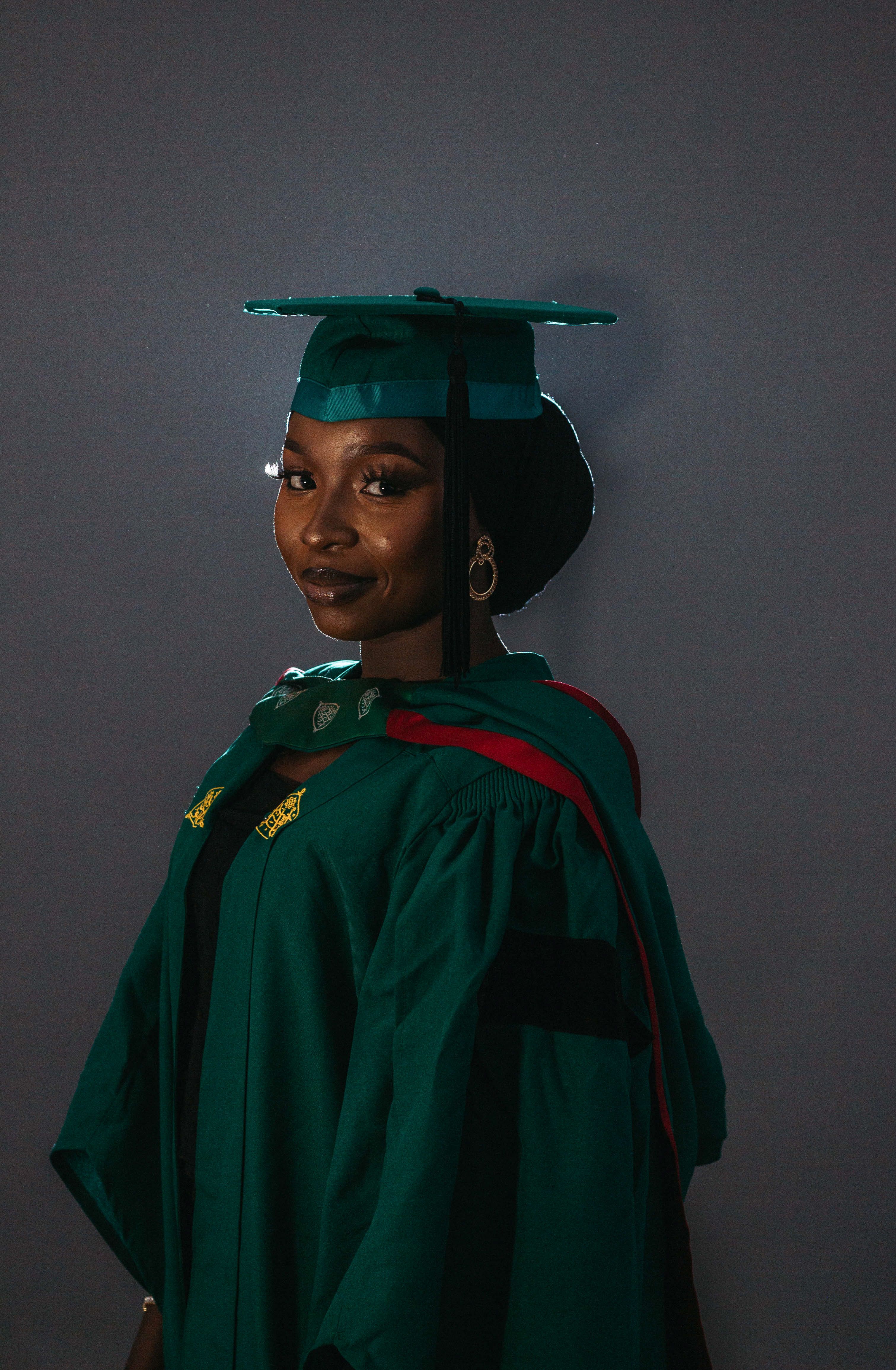 Portrait of Graduate in Green Gown Celebrating · Free Stock Photo