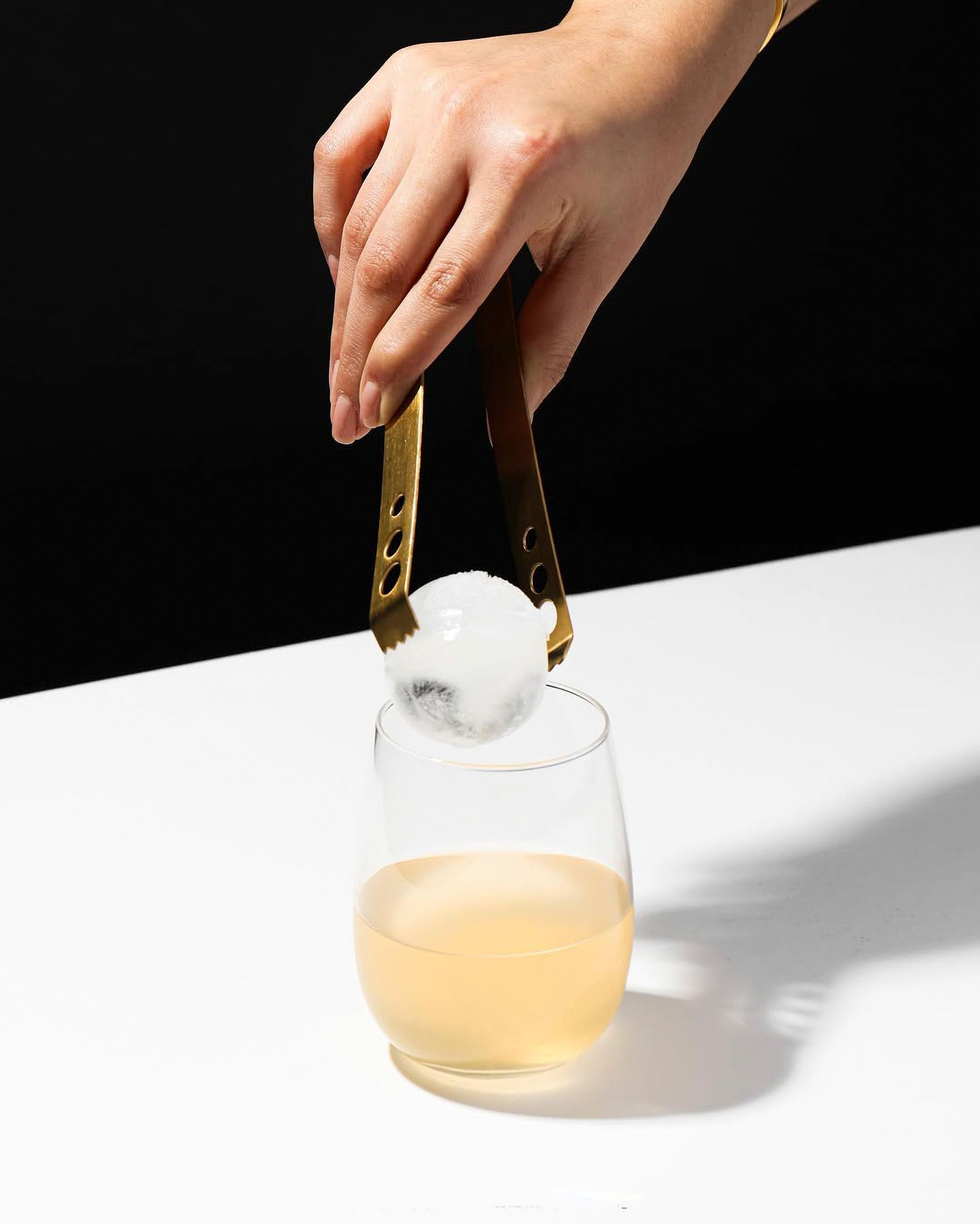 Hand Adding Ice Sphere to a Cocktail Glass · Free Stock Photo