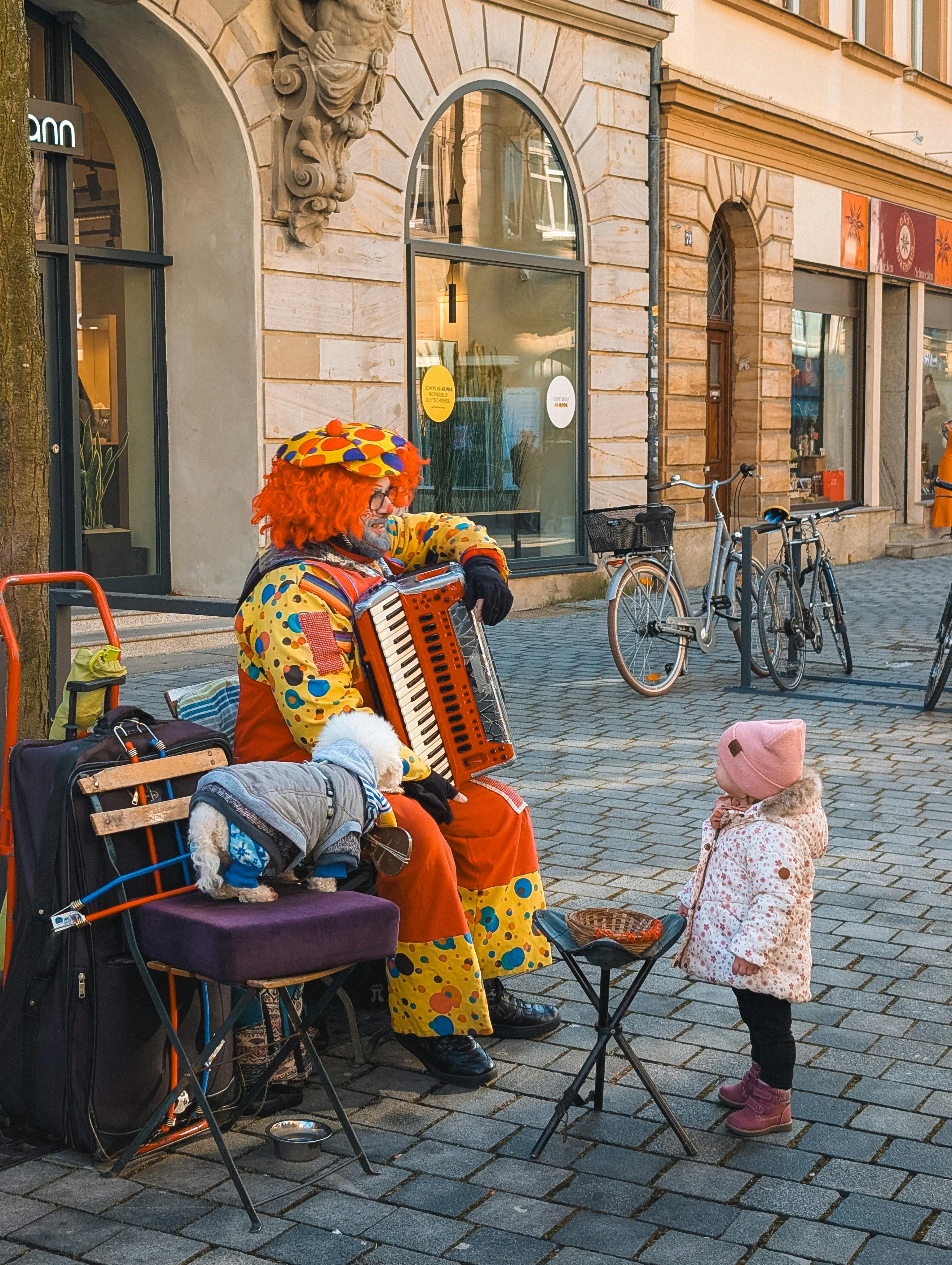Street Clown Entertains Child with Accordion · Free Stock Photo