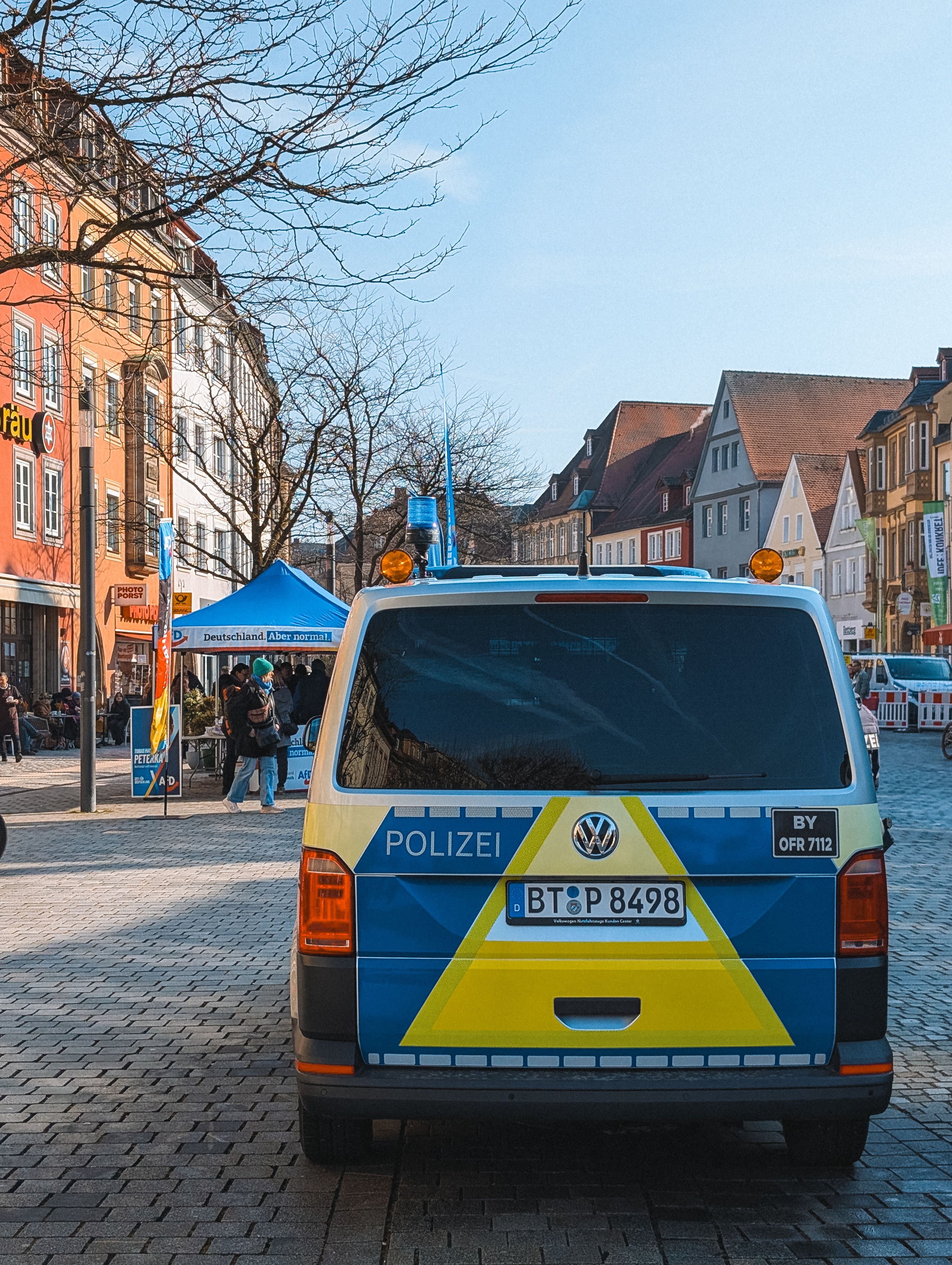 German Police Van in Cobblestone City Square · Free Stock Photo