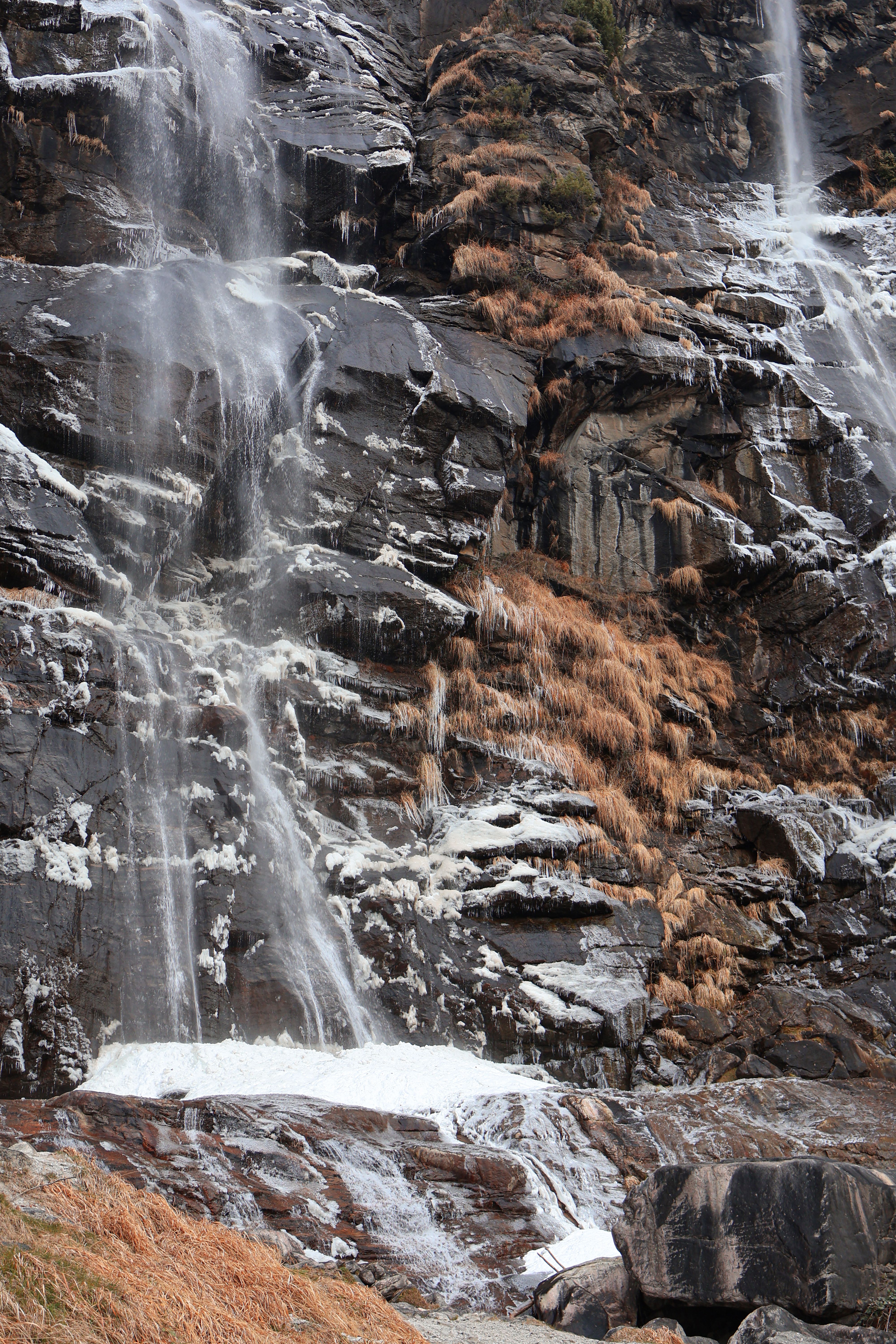 Free A stunning frozen waterfall cascading down rocky terrain in ...