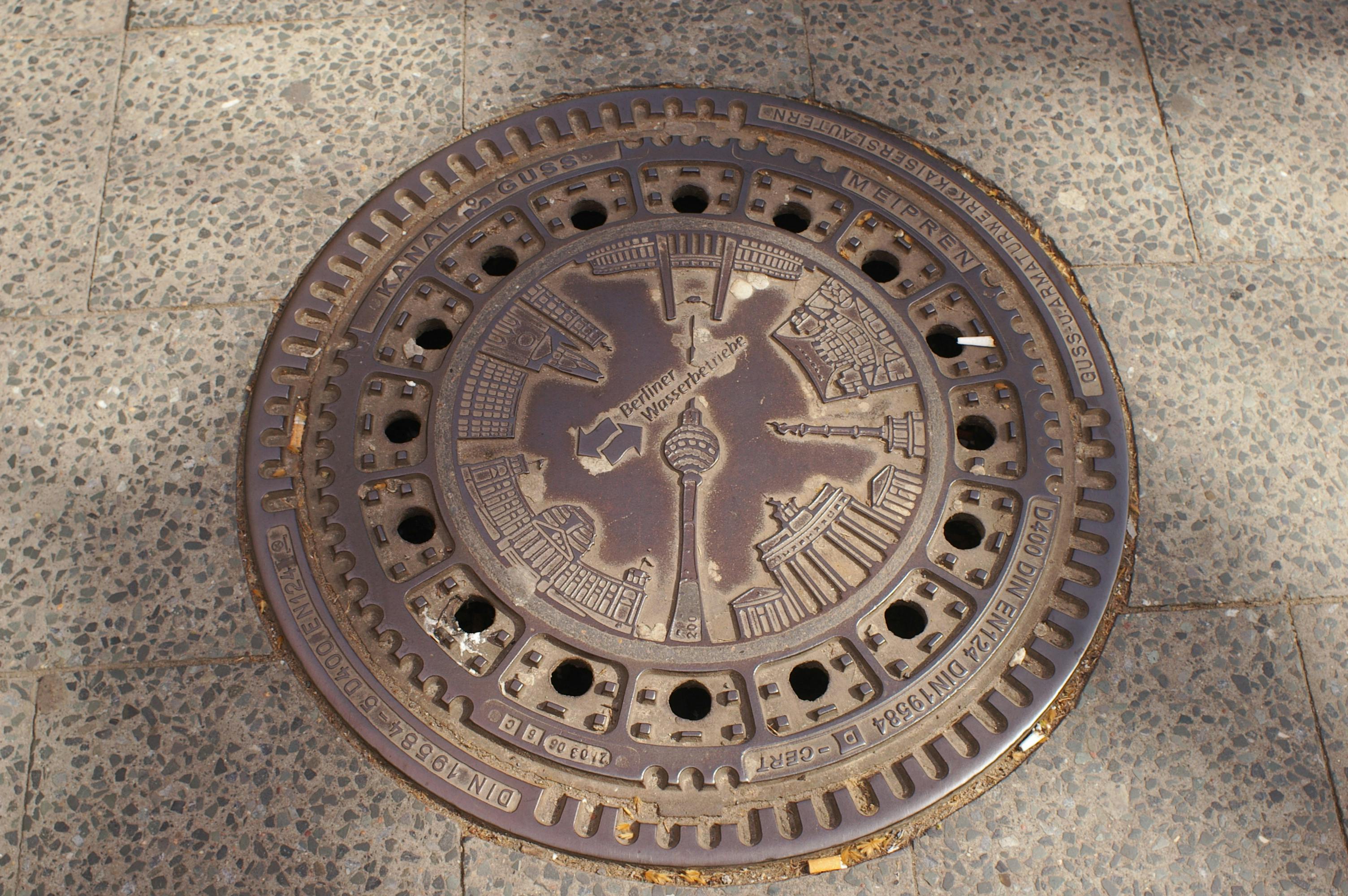 Decorative Berlin Manhole Cover with Cityscape Design · Free Stock Photo
