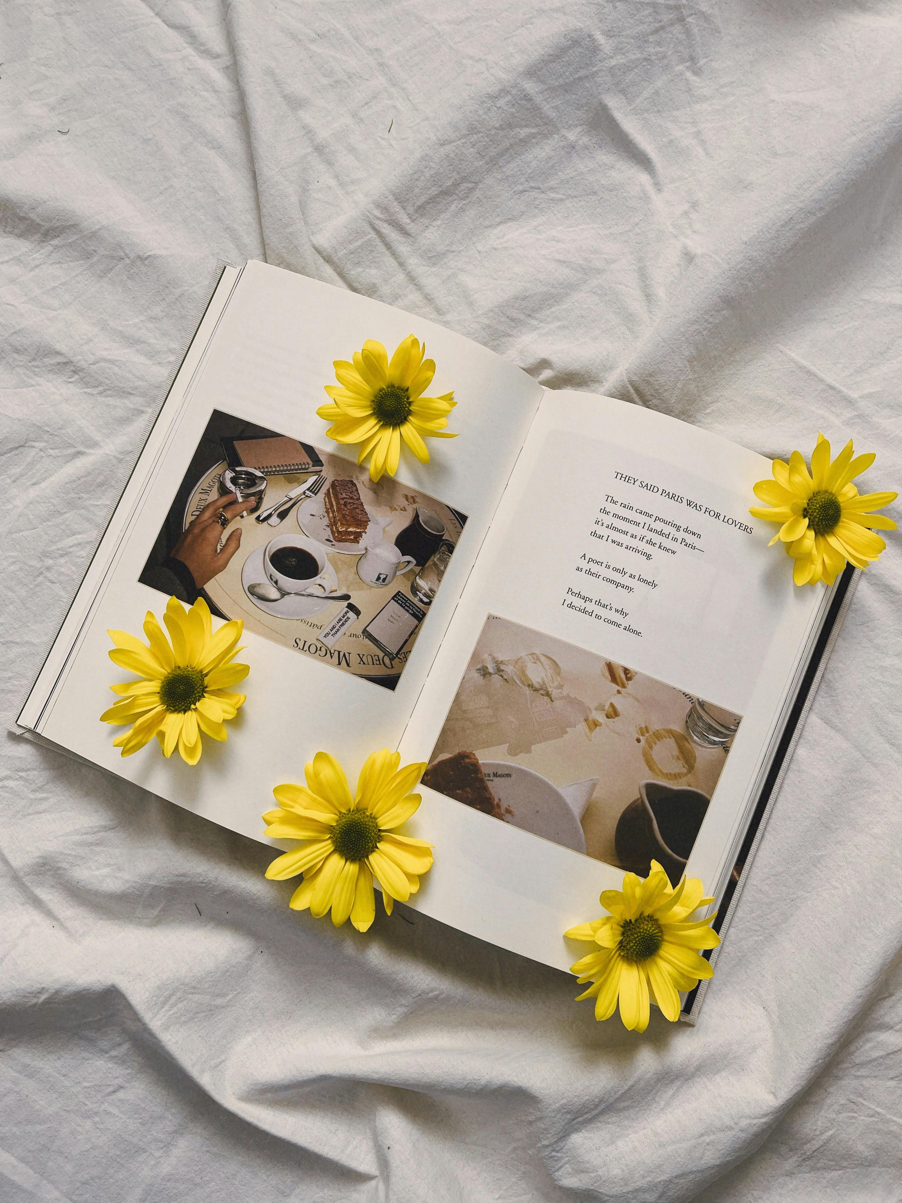 Aesthetic Open Book with Yellow Flowers on White Cloth · Free Stock Photo