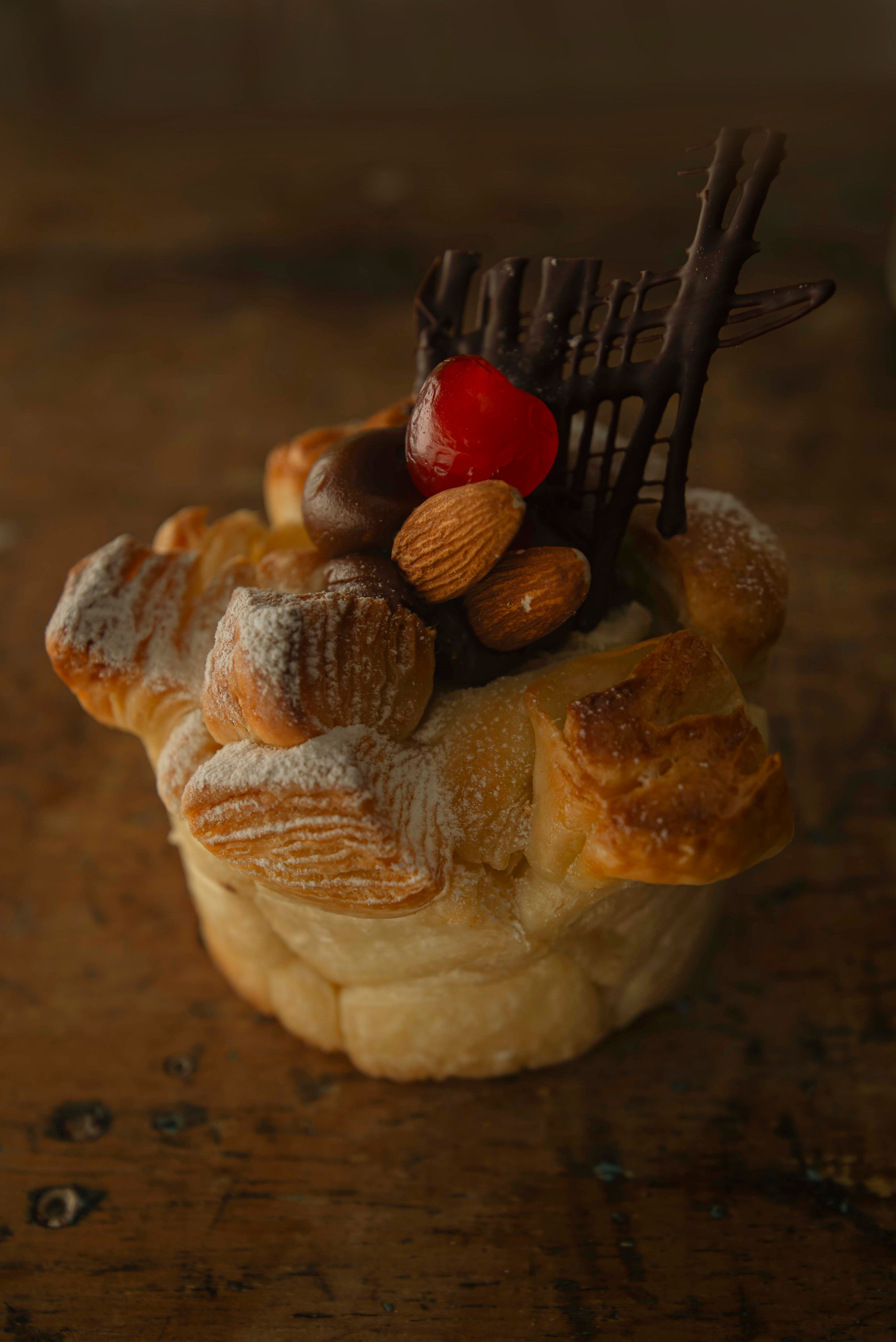 Close-up of a Gourmet Pastry with Nuts and Cherry · Free Stock Photo