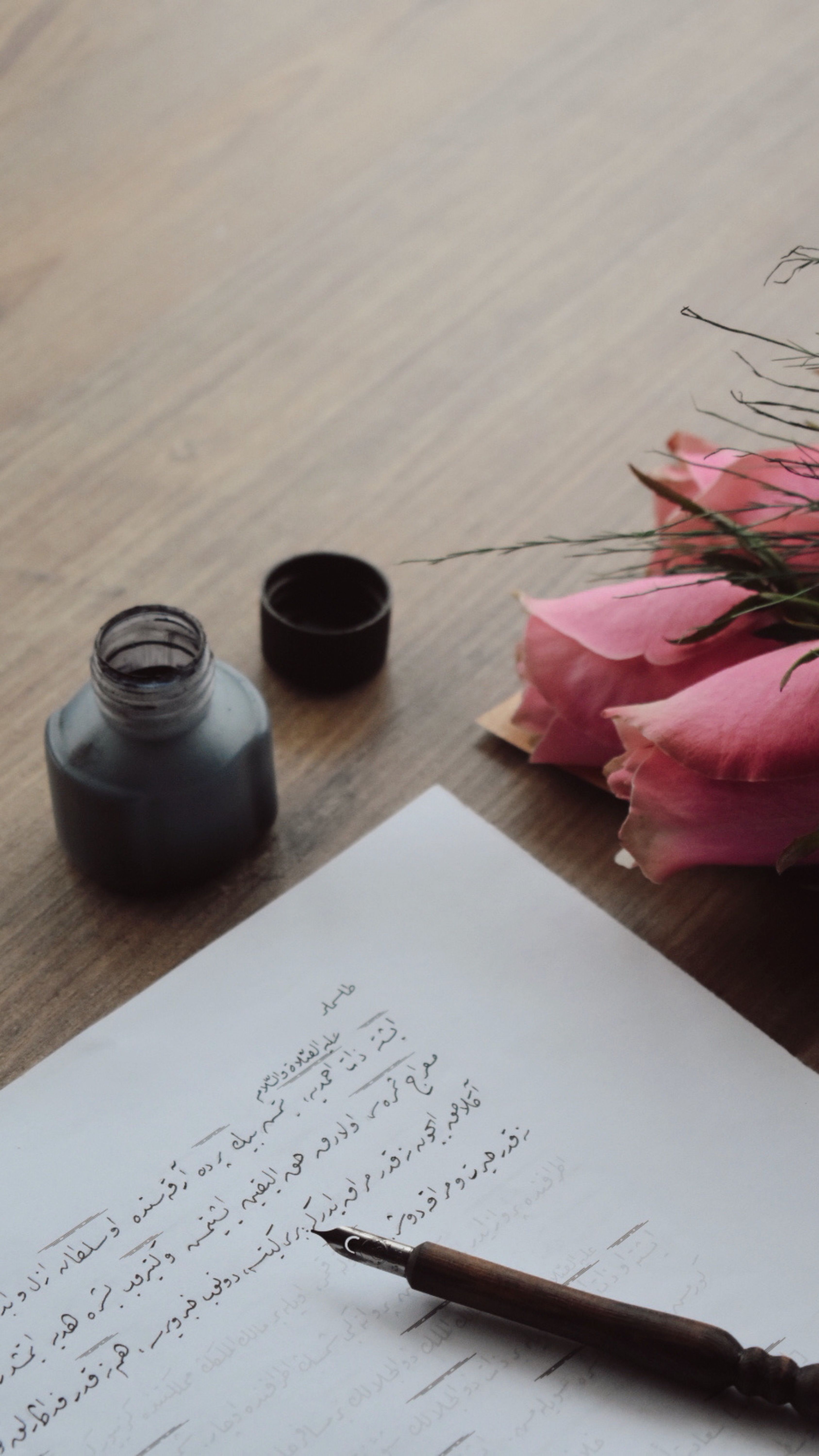 Elegant Calligraphy with Roses and Ink on Wooden Desk · Free Stock Photo
