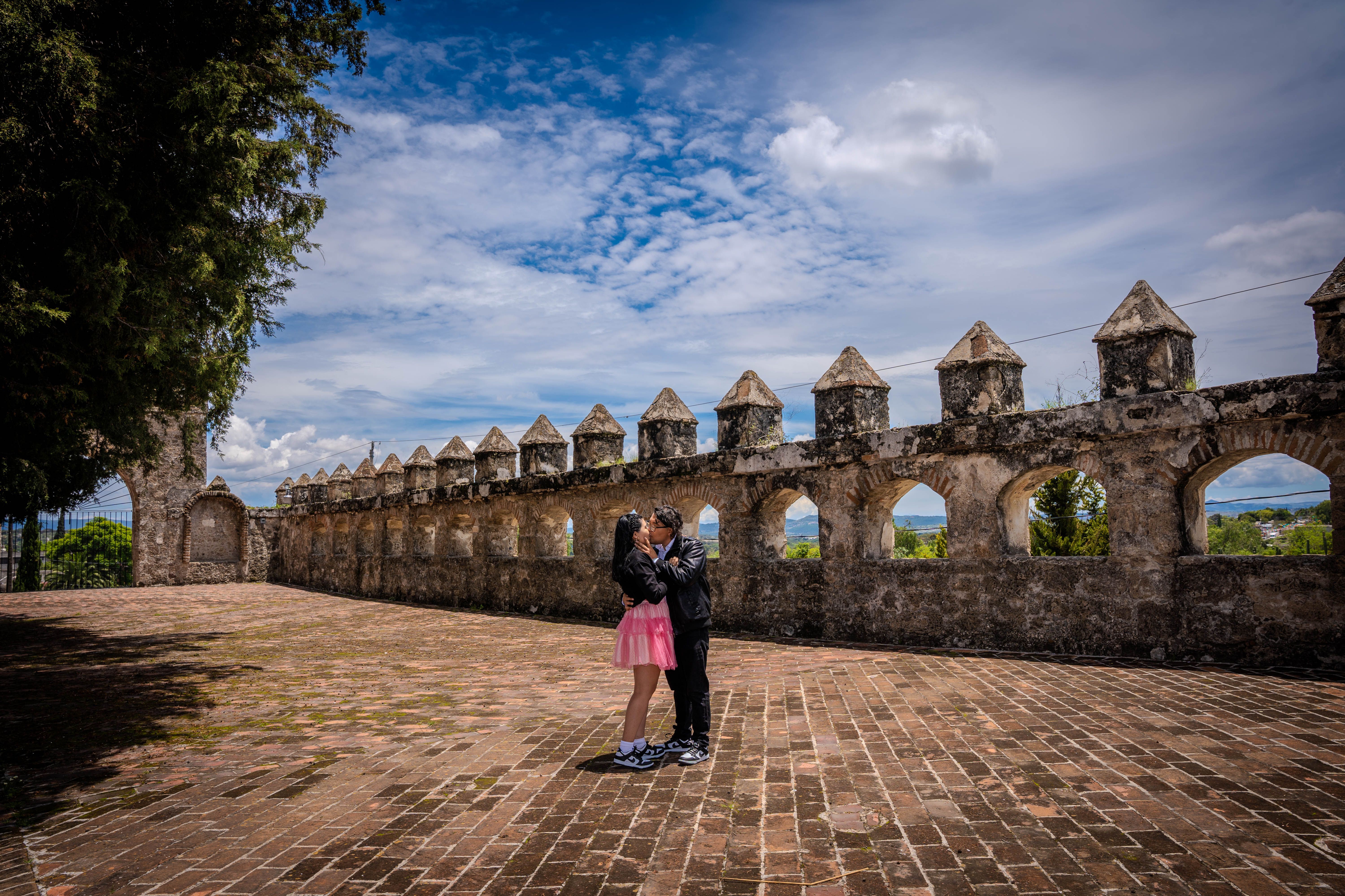 Romantic Couple Embracing by Historic Stone Wall · Free Stock Photo