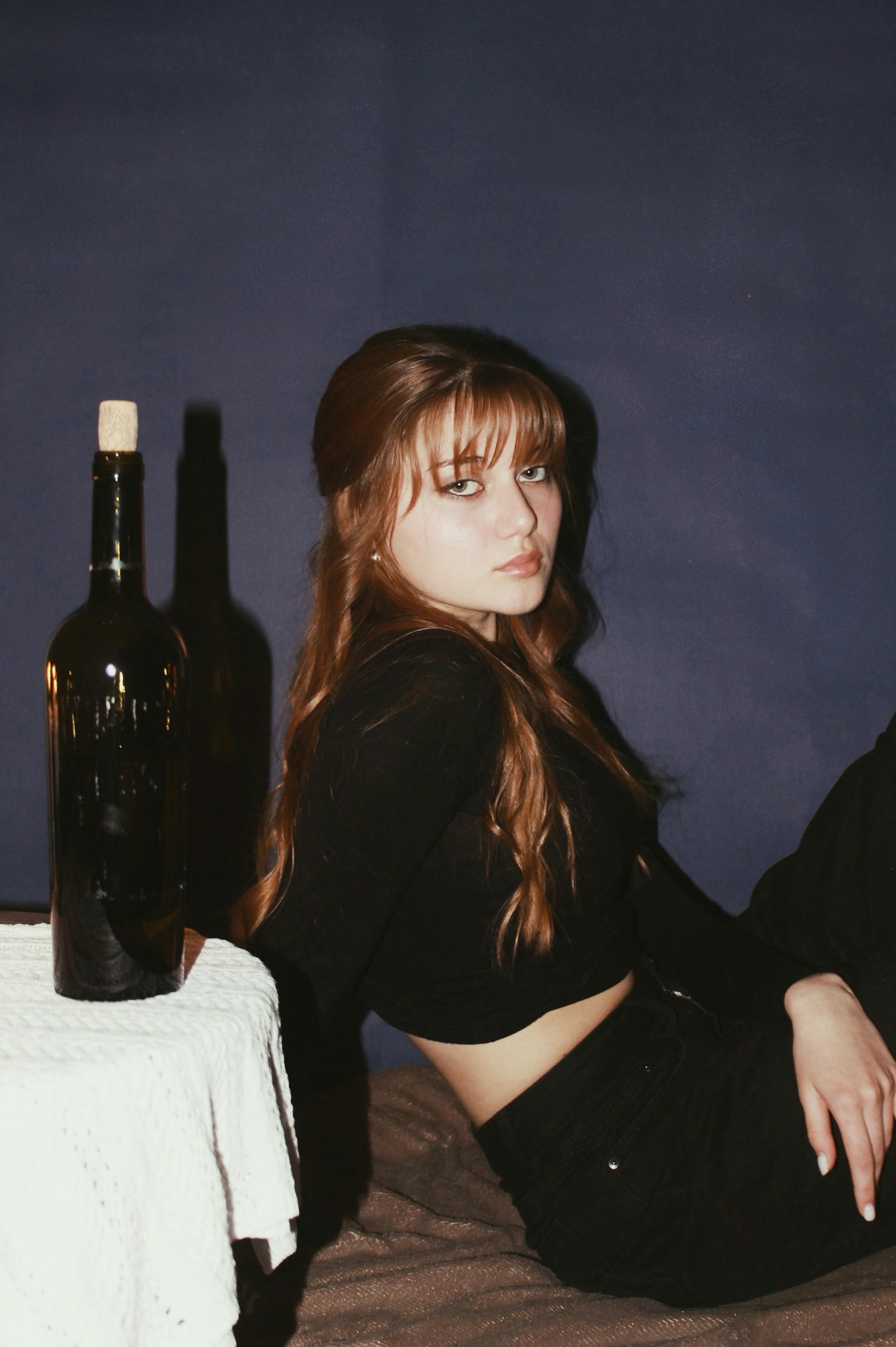 Moody Portrait with Wine Bottle Indoors · Free Stock Photo