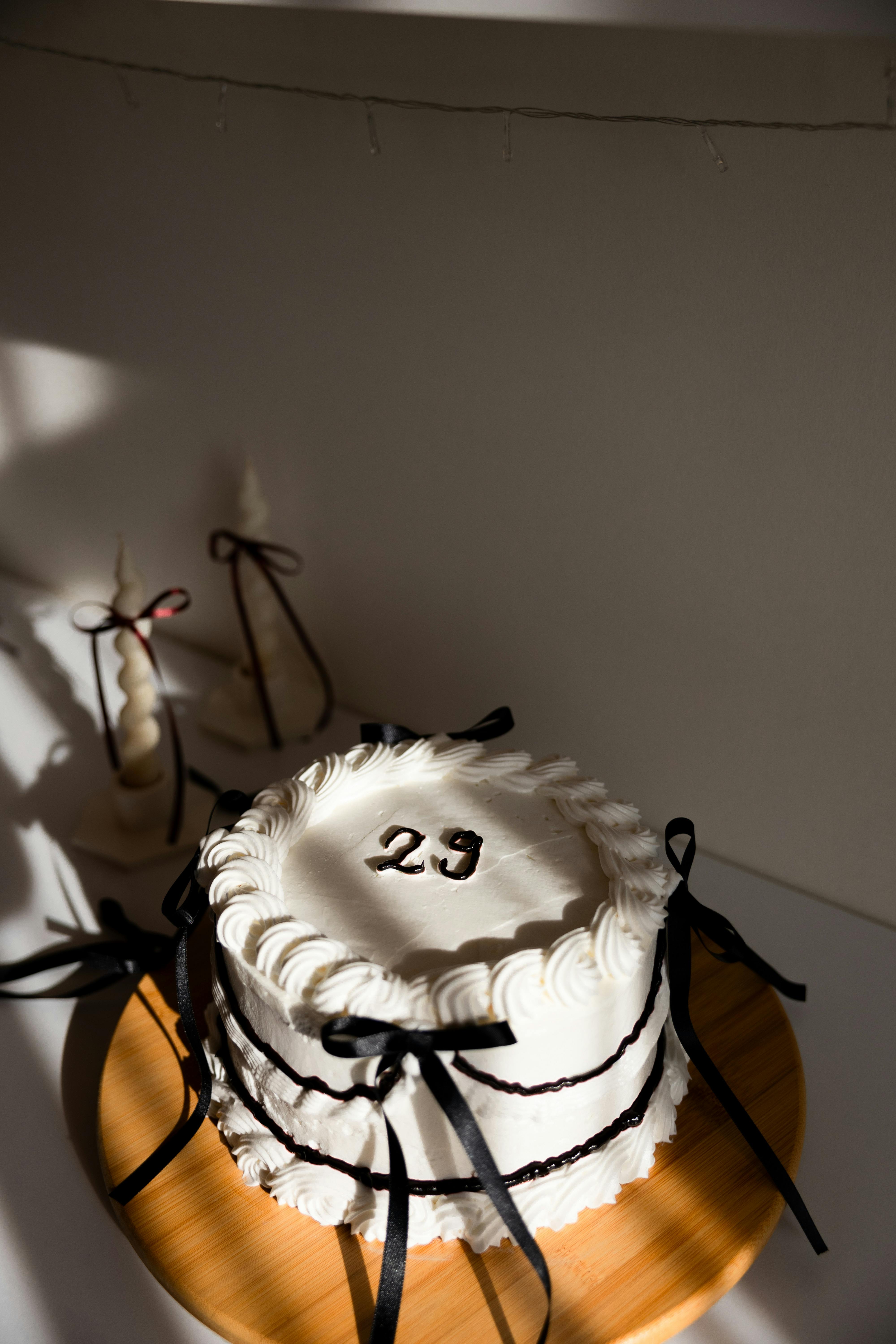 Elegant Birthday Cake with Black Ribbon Accents · Free Stock Photo