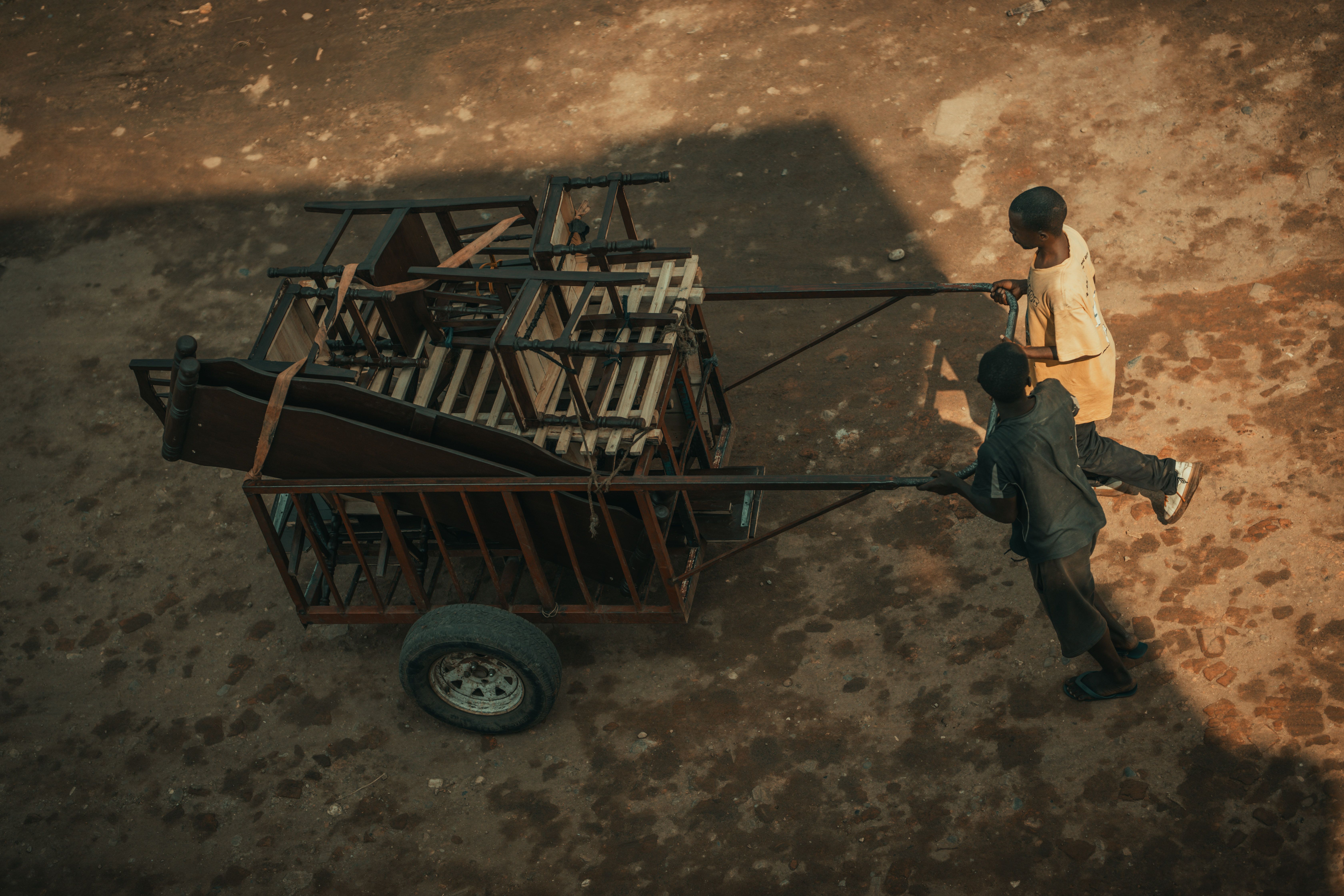 Children Pushing Wooden Cart on Dirt Path · Free Stock Photo