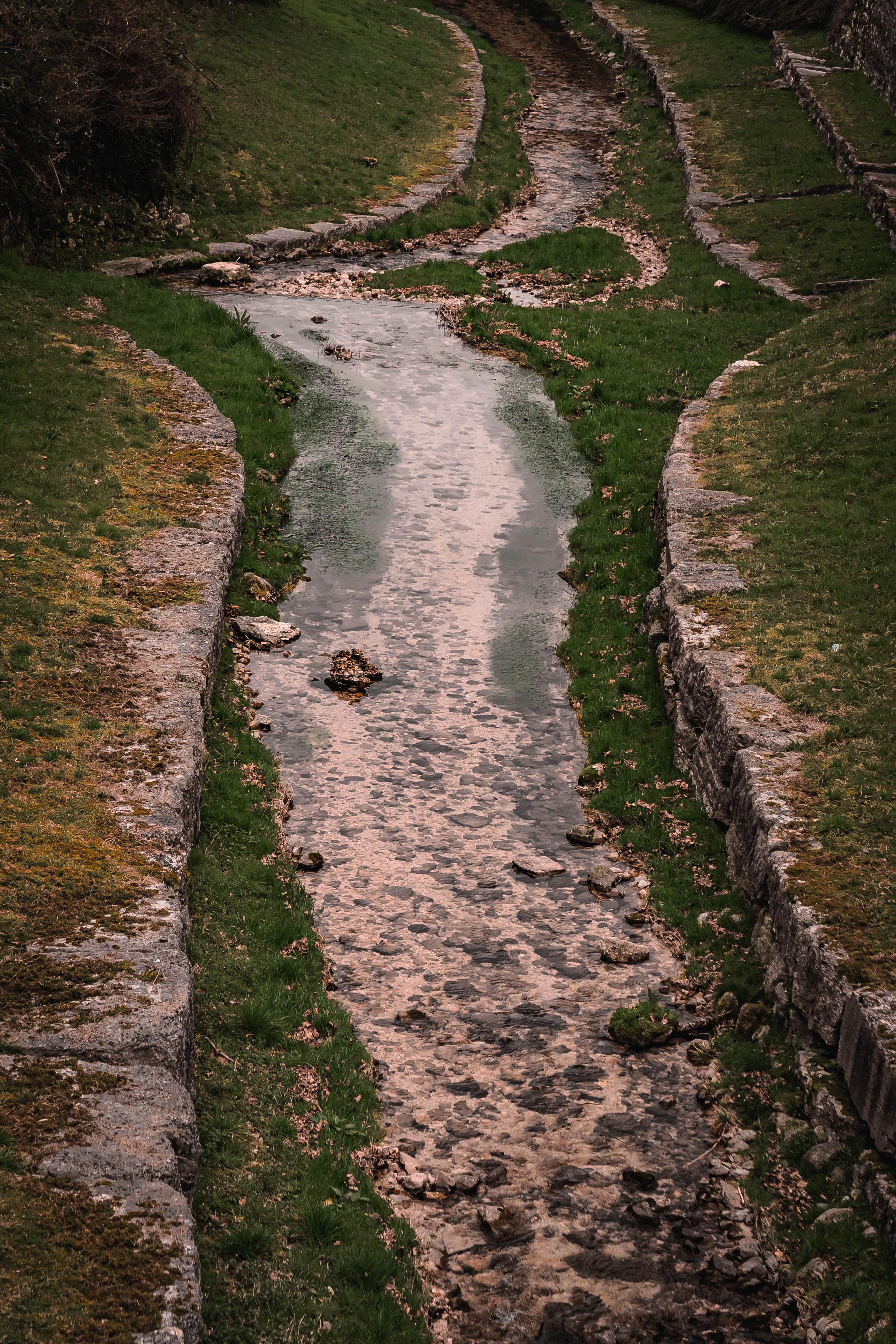 Tranquil Stone-lined Stream in Natural Setting · Free Stock Photo