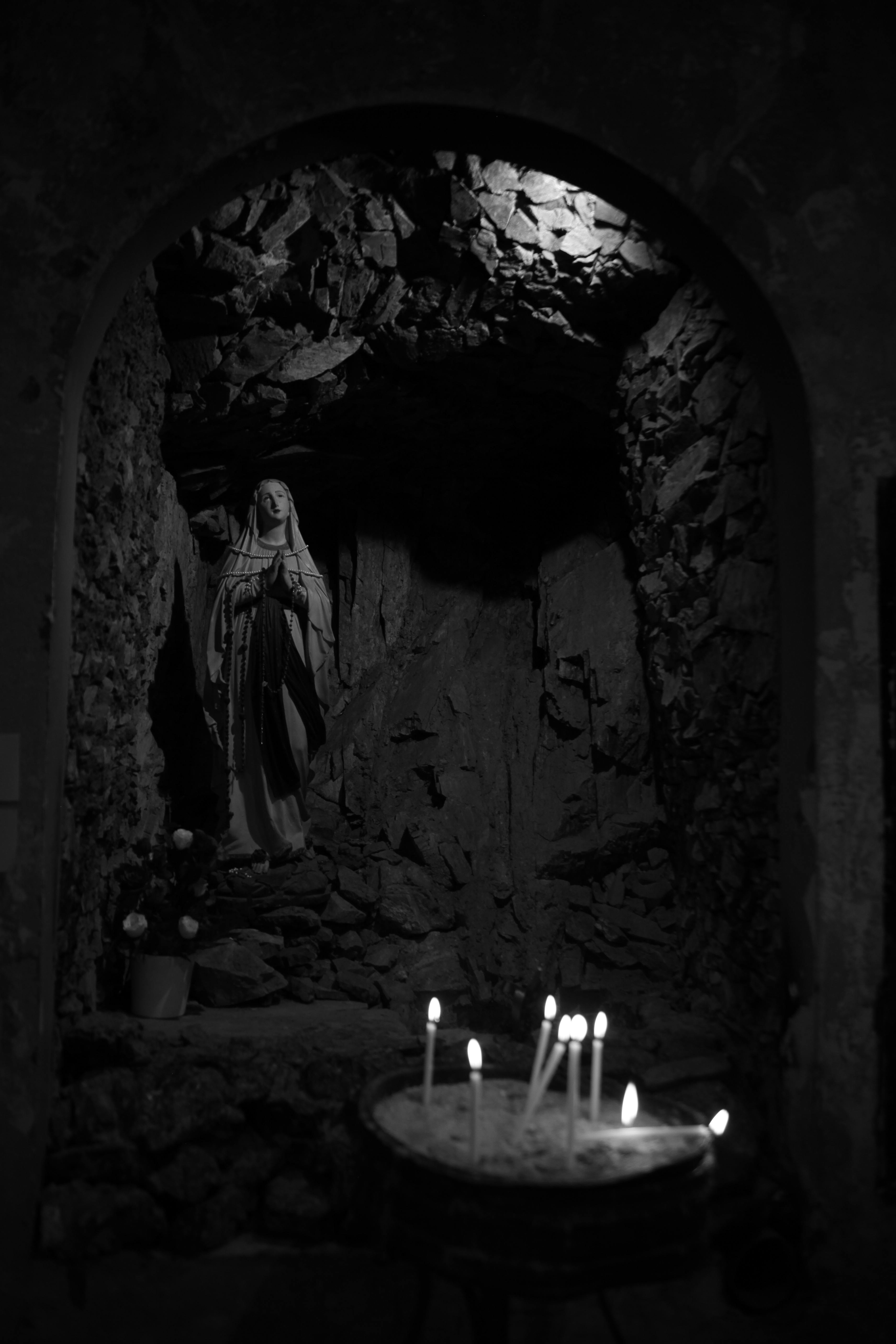 Black and White Religious Statue with Candles · Free Stock Photo