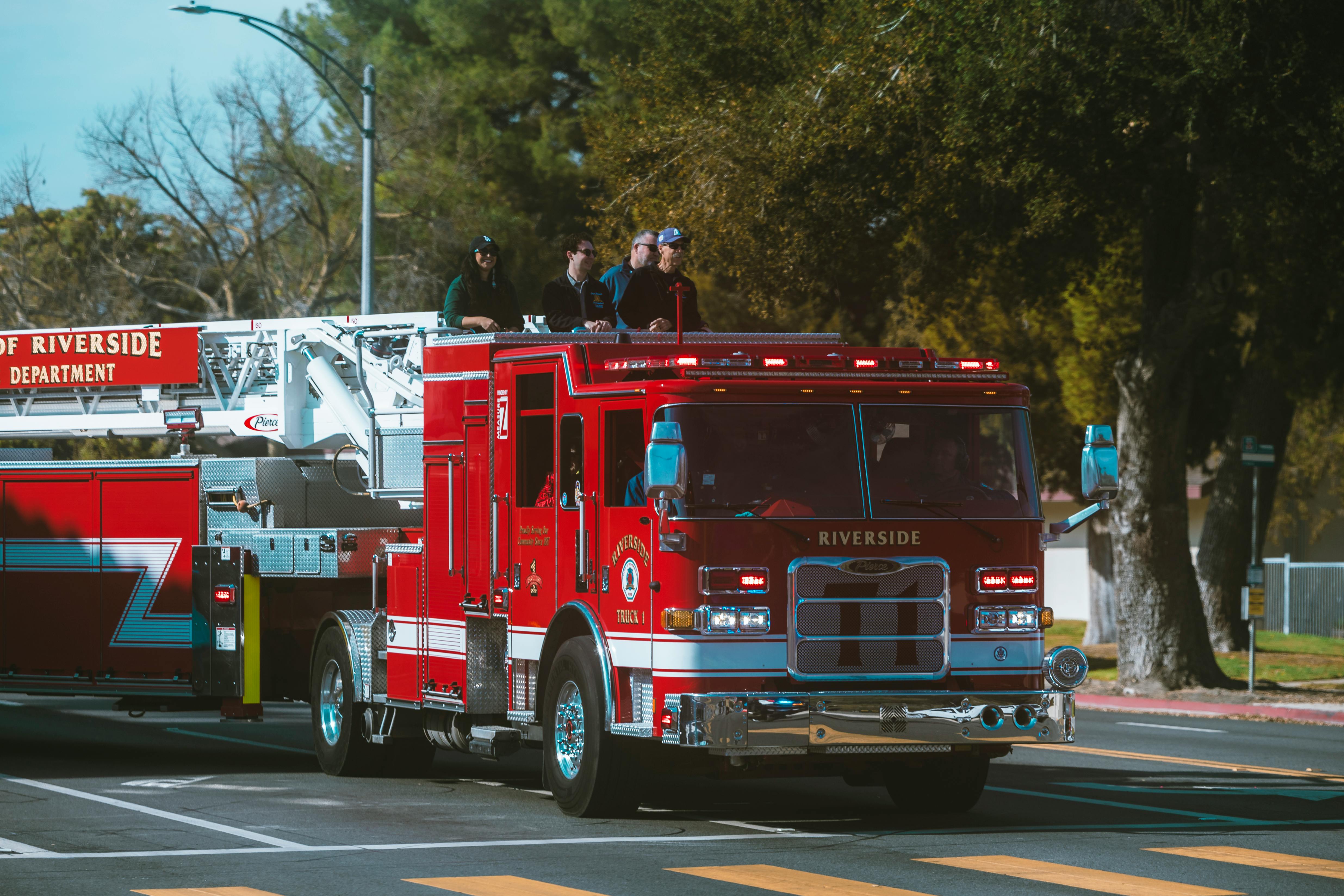 Fire engine truck driving along narrow busy street · Free Stock Photo