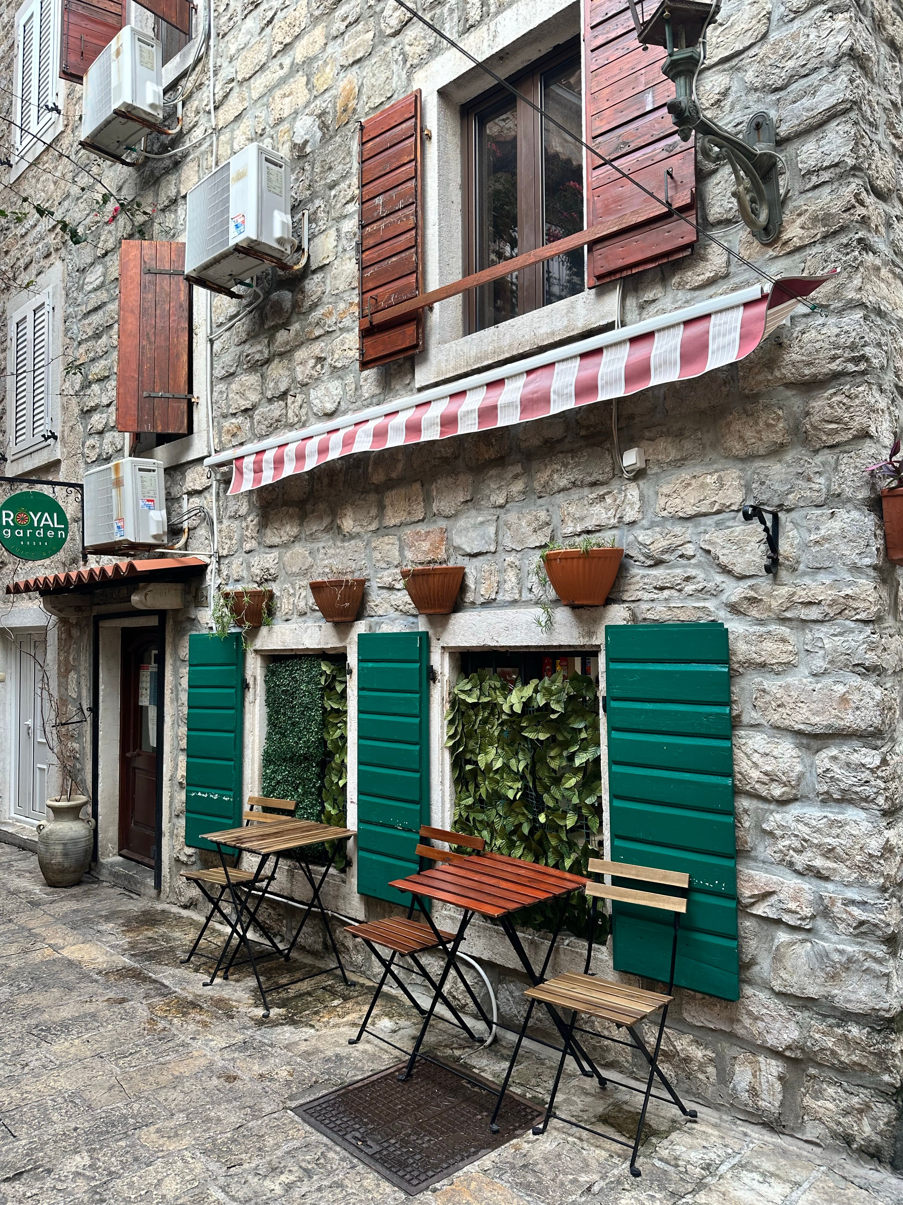 Charming European Cafe with Rustic Stone Wall · Free Stock Photo