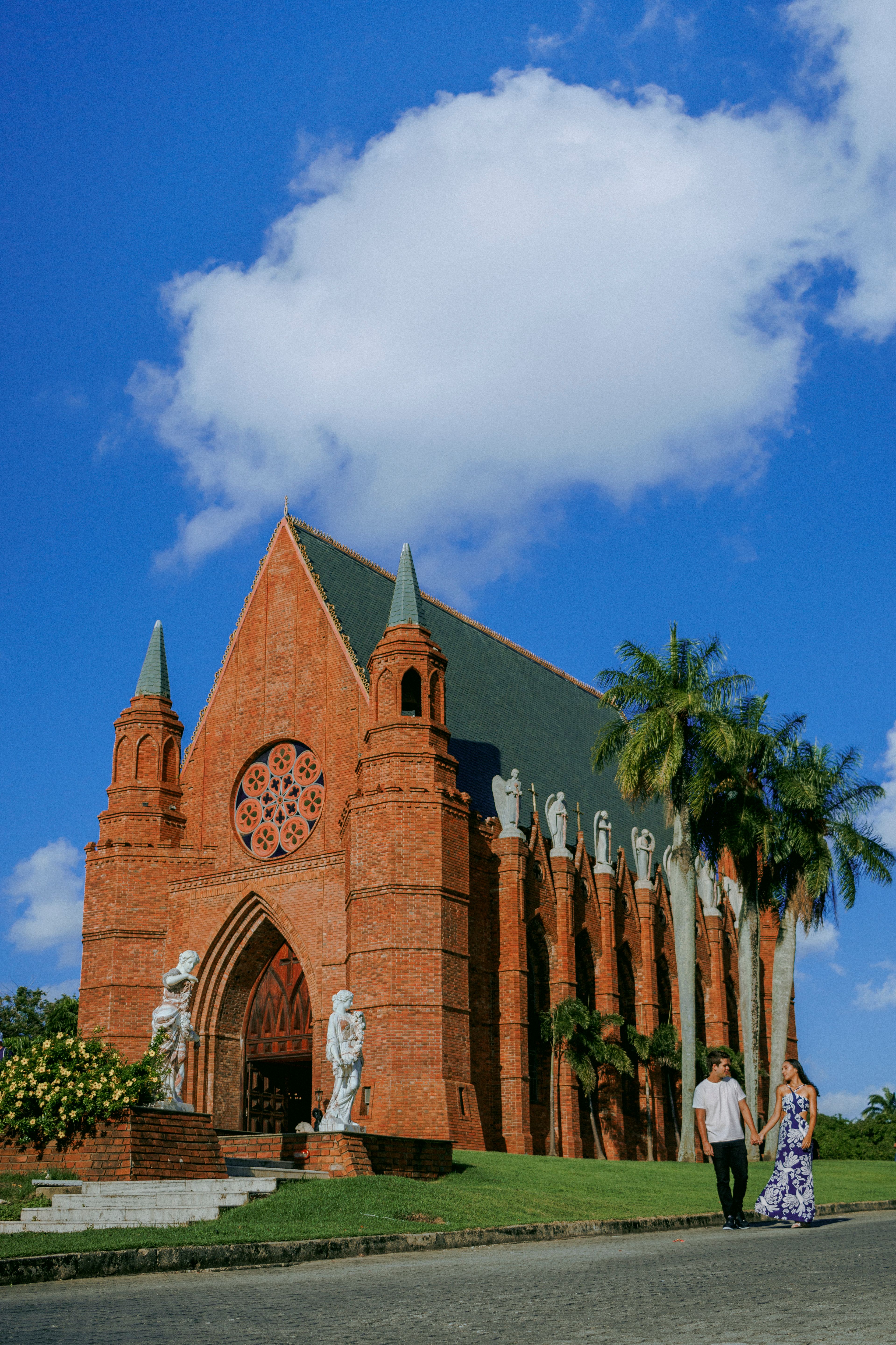 Red Brick Gothic Chapel with Palm Trees in Sunlight · Free Stock Photo