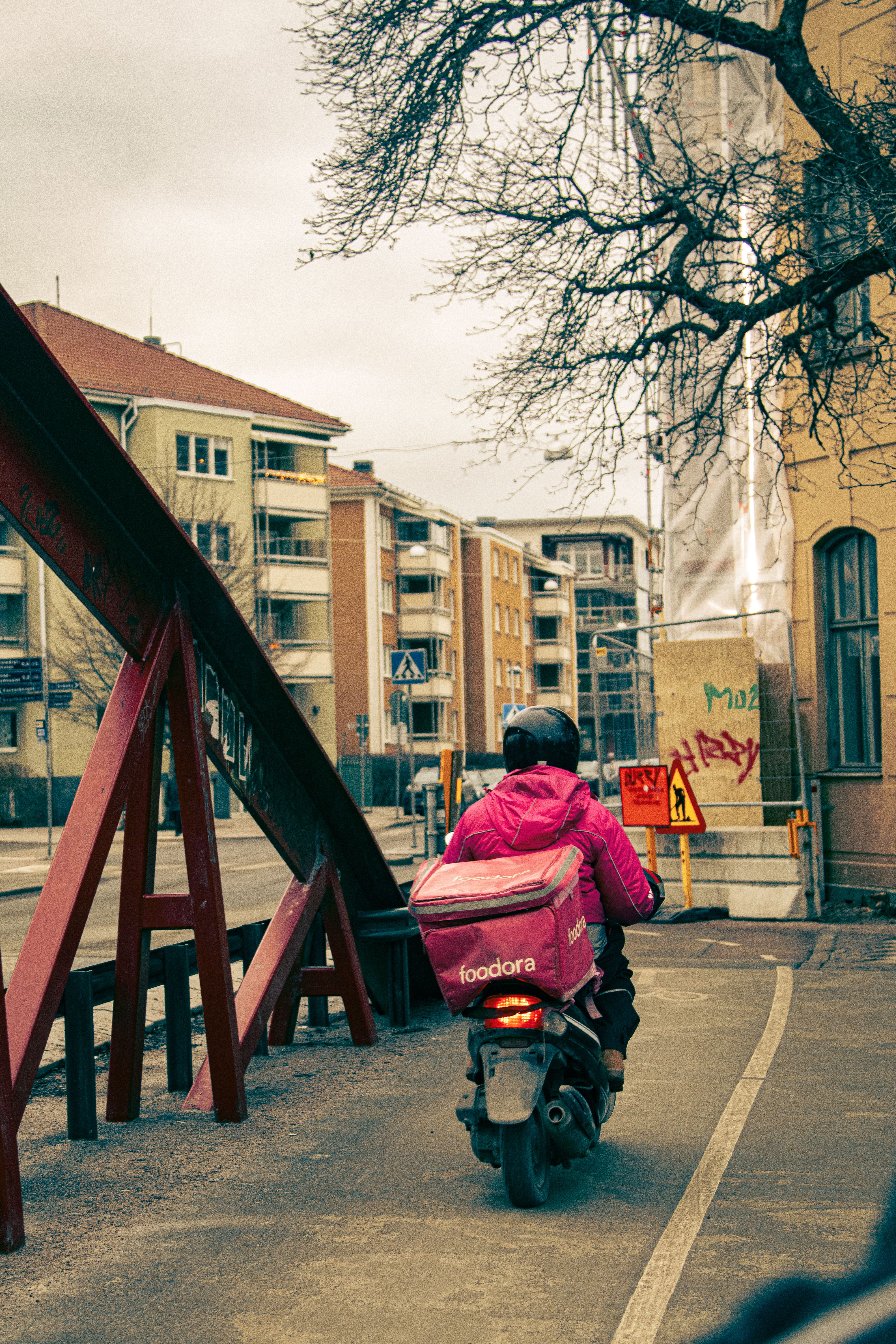 Food Delivery Rider on Scooter in Urban Setting · Free Stock Photo