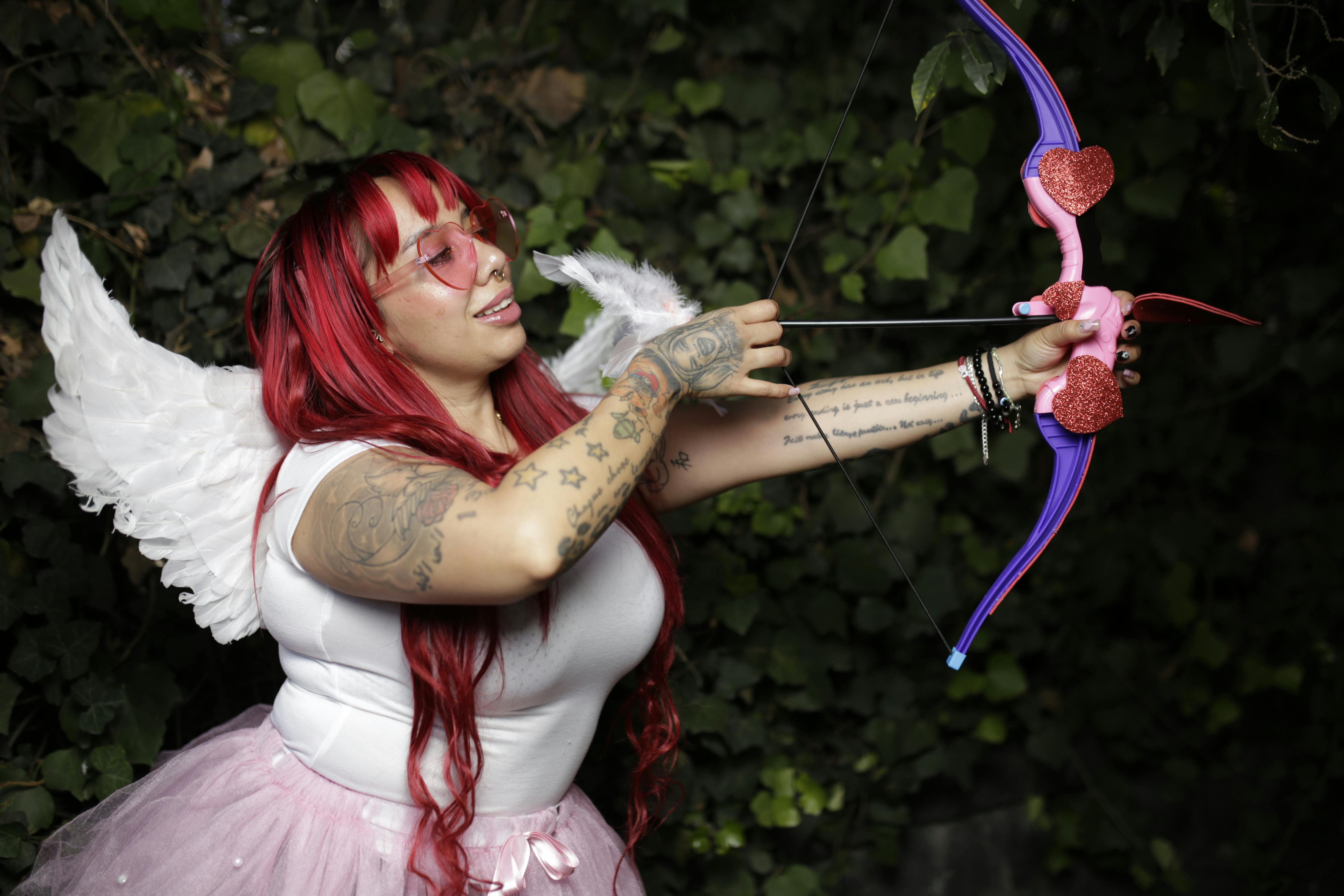 Playful Cupid Archery Scene in Urban Garden · Free Stock Photo