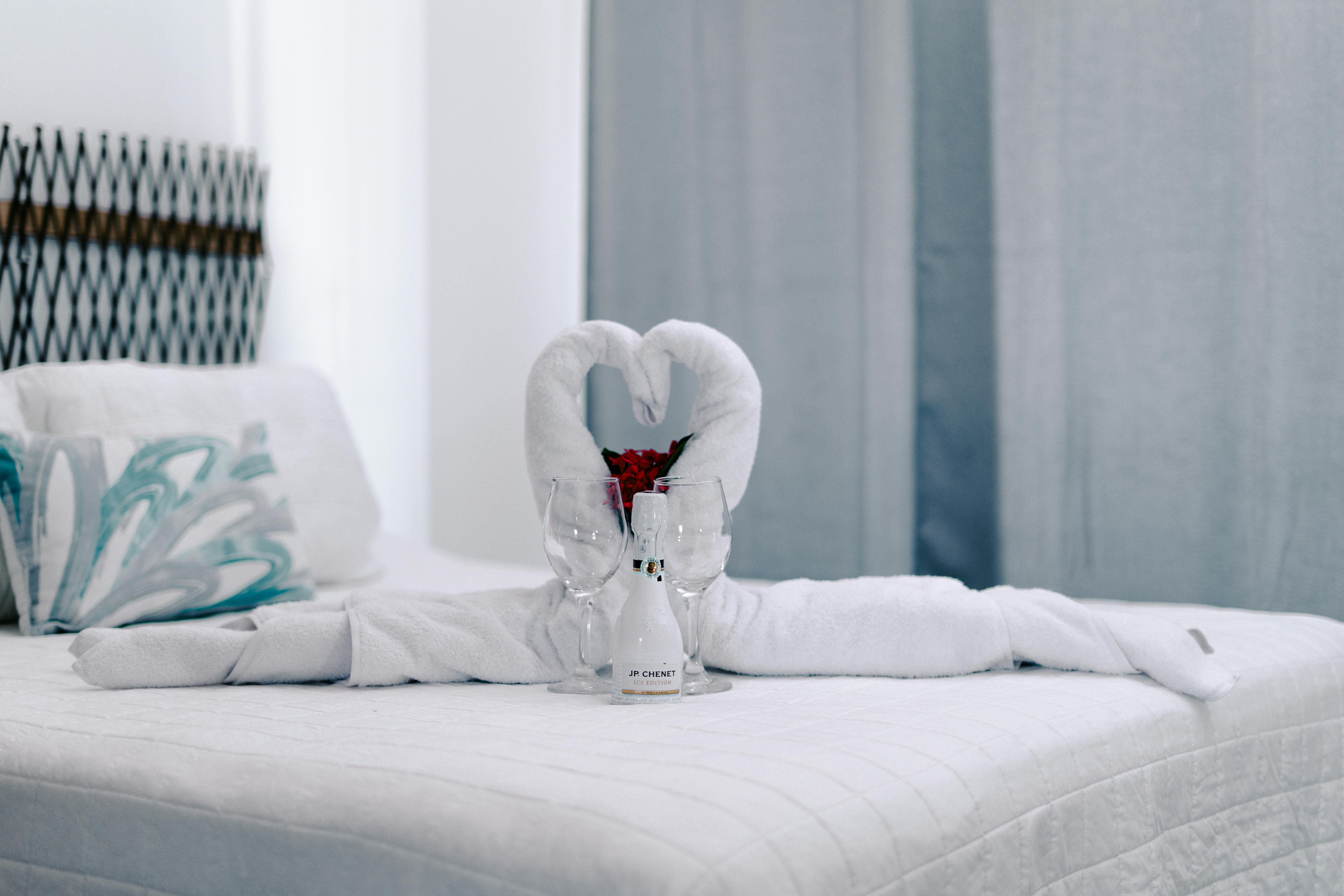 Romantic Towel Swan Setup on Bed with Champagne · Free Stock Photo