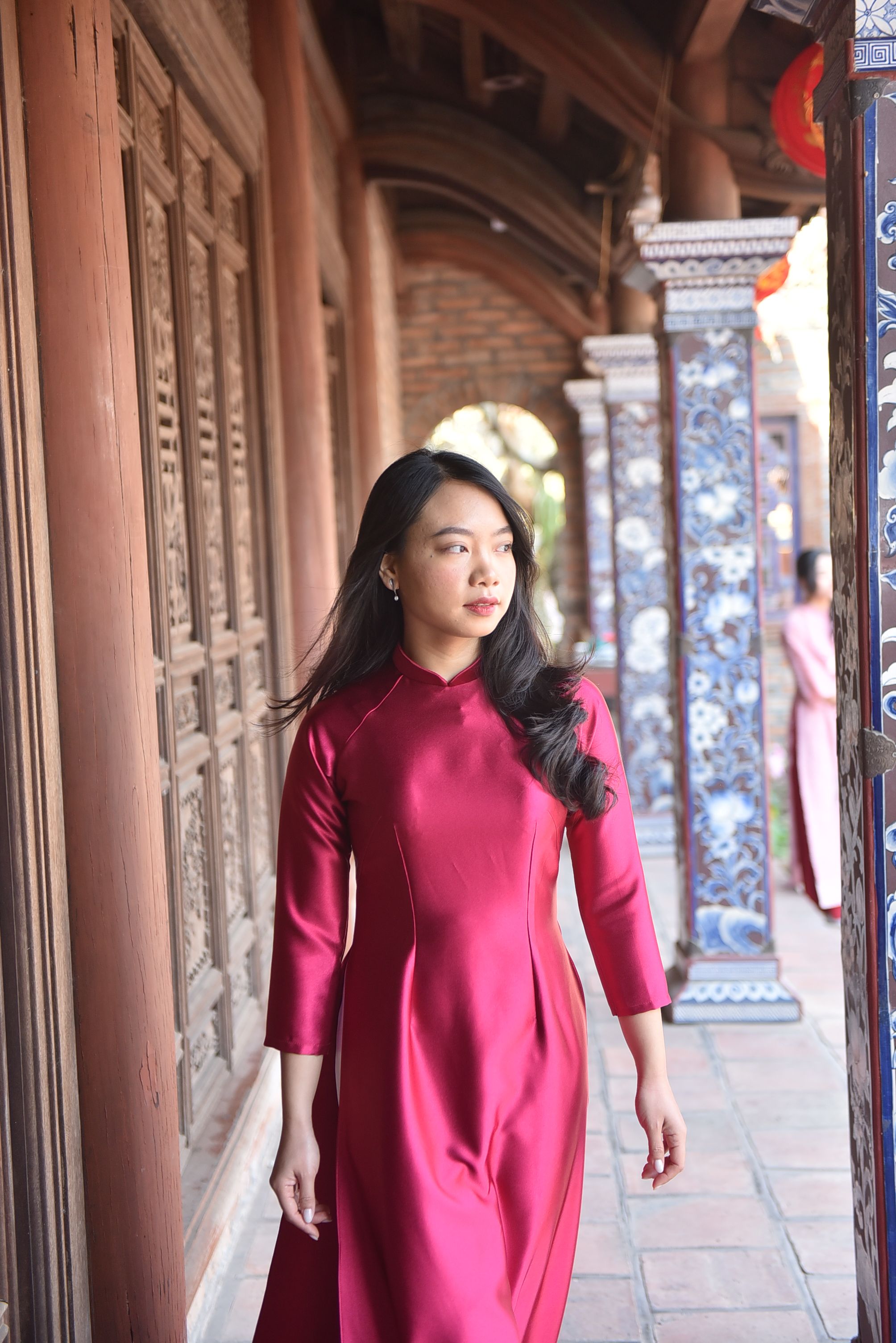Woman in Traditional Dress Walking in Temple Corridor · Free Stock Photo