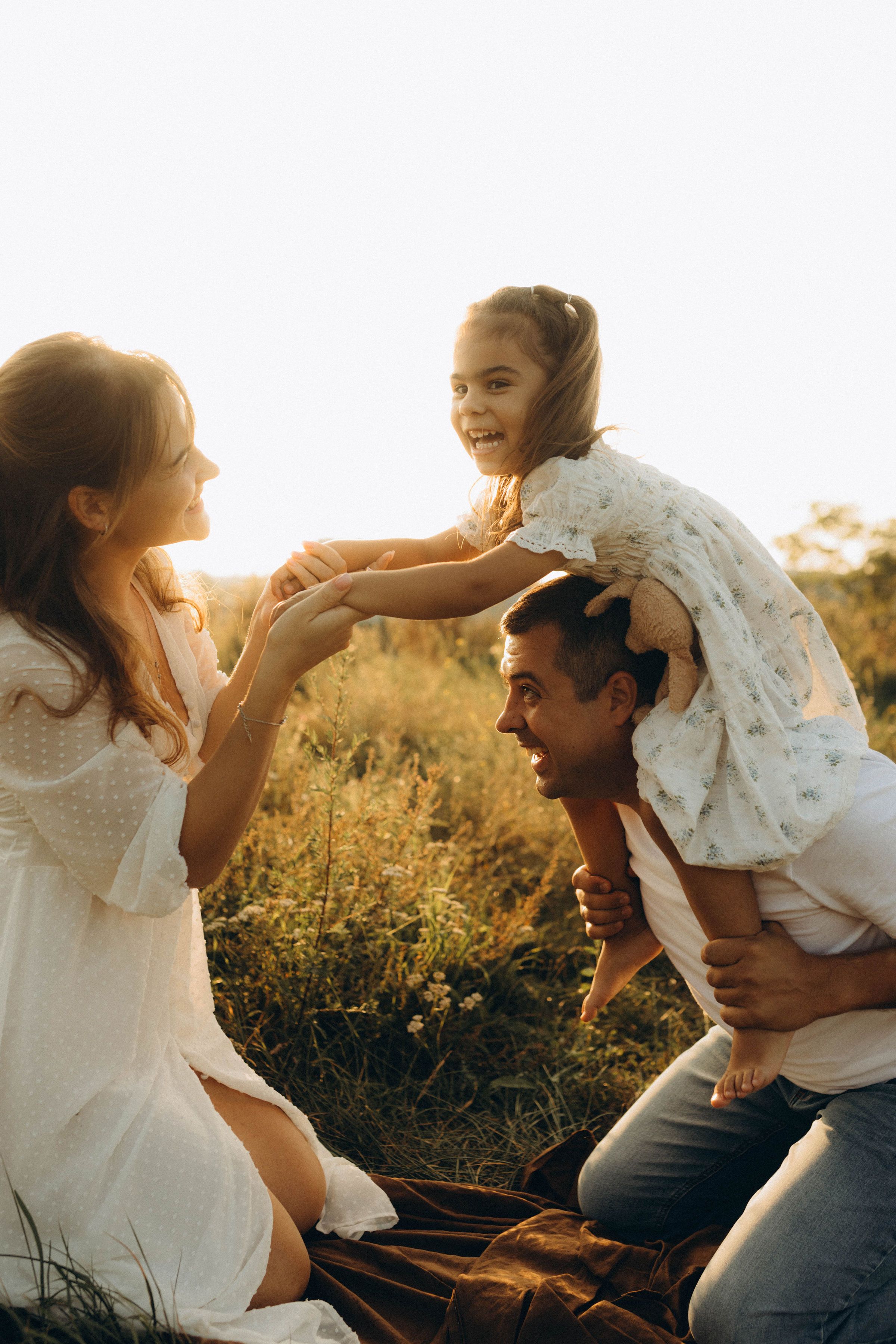 Joyful Family Moment in a Sunny Meadow · Free Stock Photo