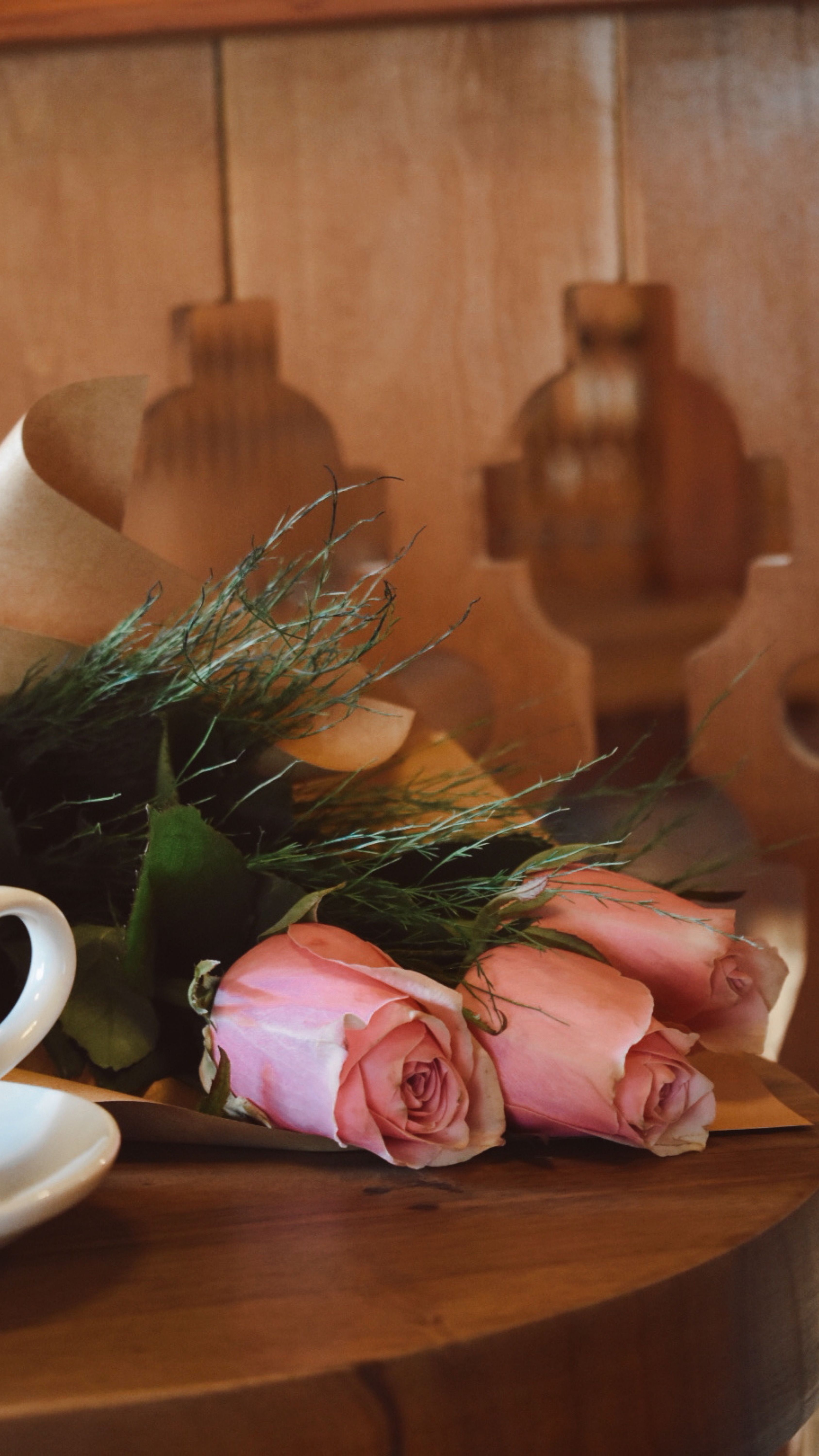 Elegant Pink Roses on Rustic Wooden Table · Free Stock Photo