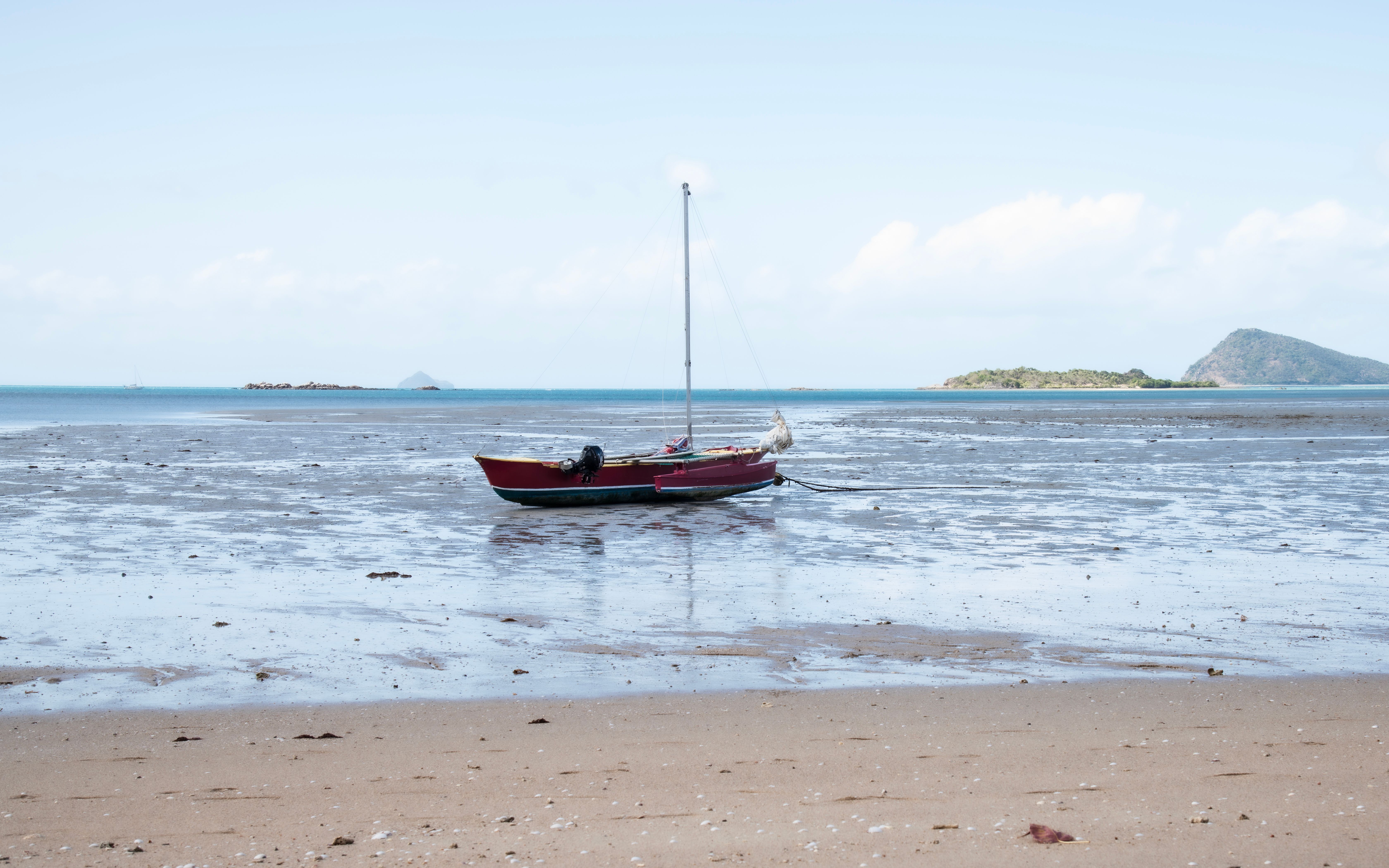 Red Boat on Serene Beach with Distant Islands · Free Stock Photo