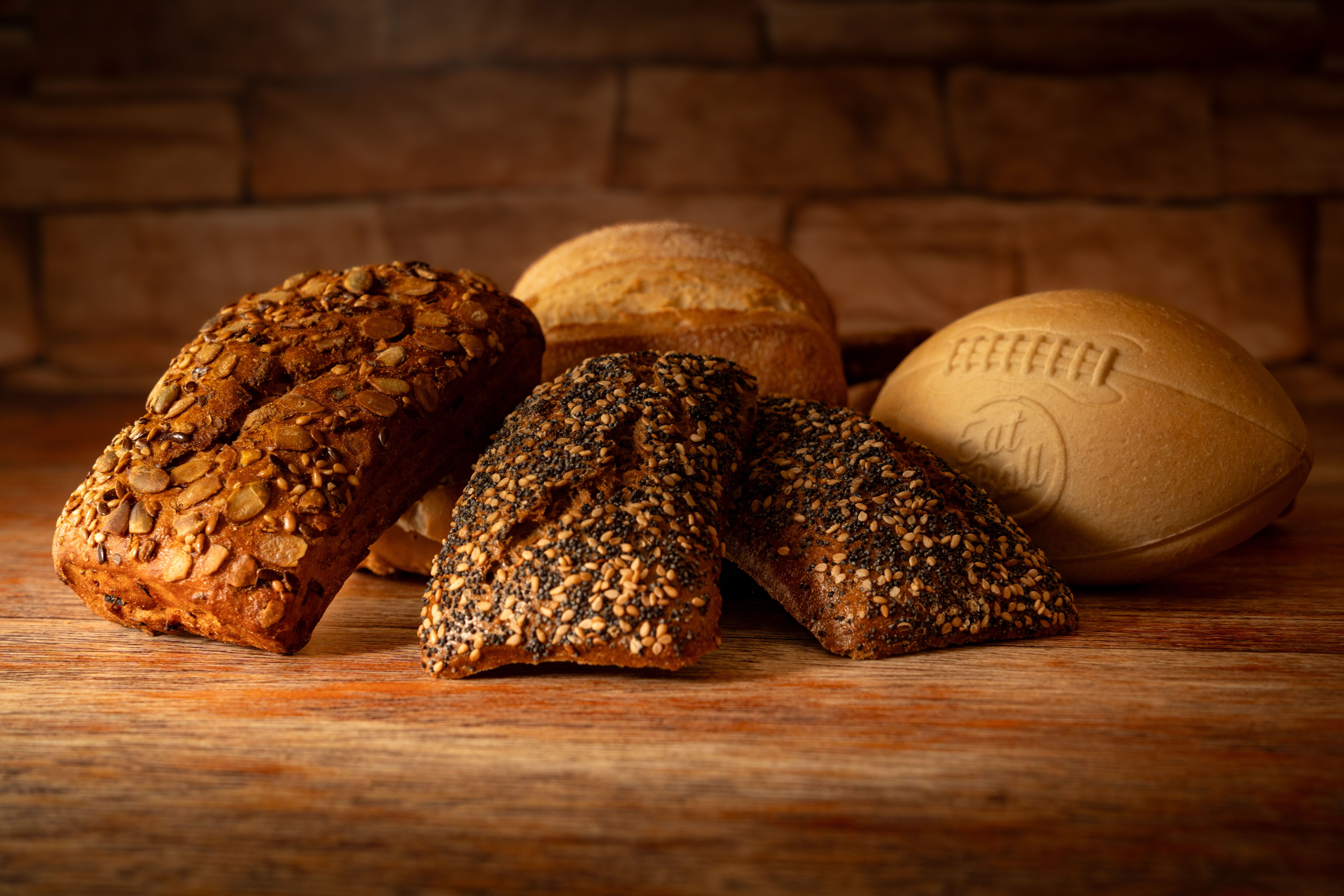 Assorted Artisan Bread Loaves on Rustic Surface · Free Stock Photo