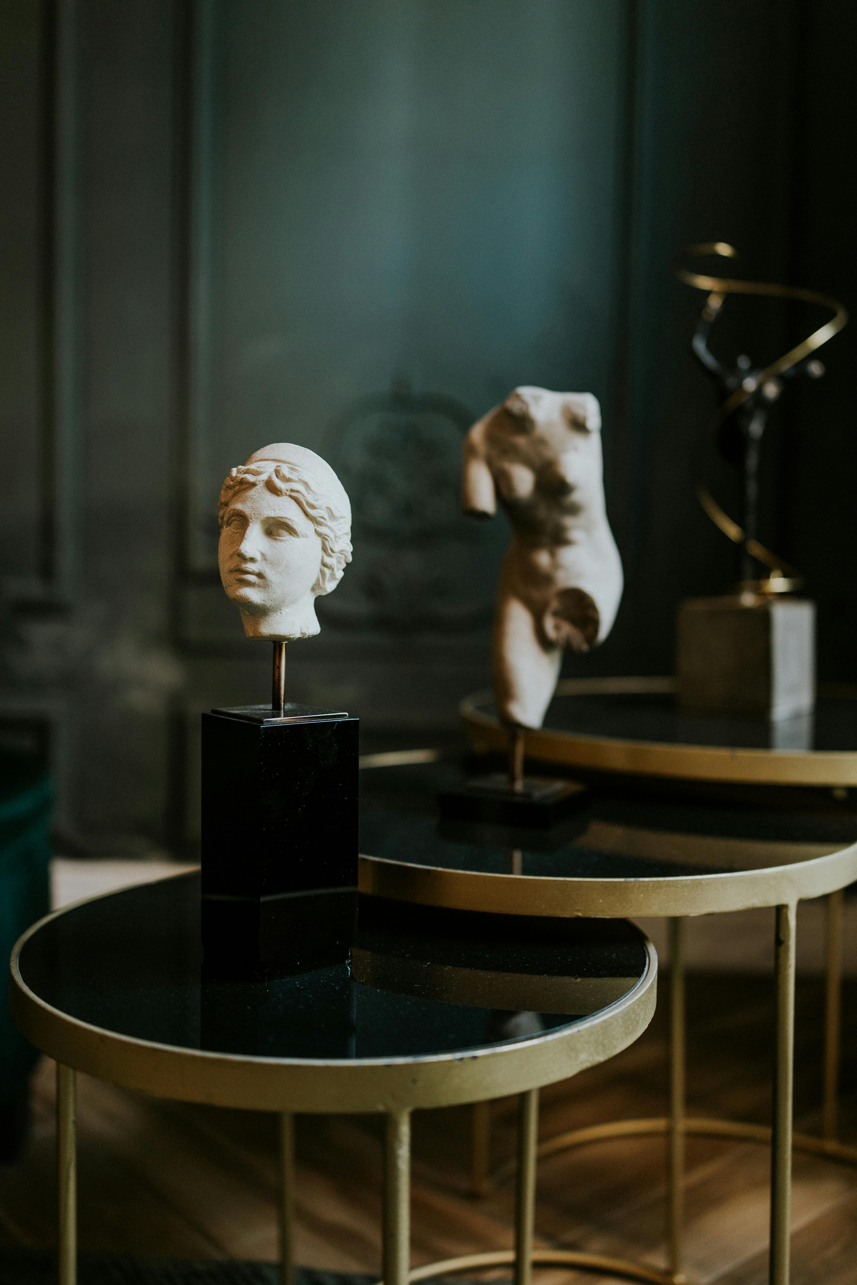 Artistic Display of Classical Sculptures on Tables · Free Stock Photo
