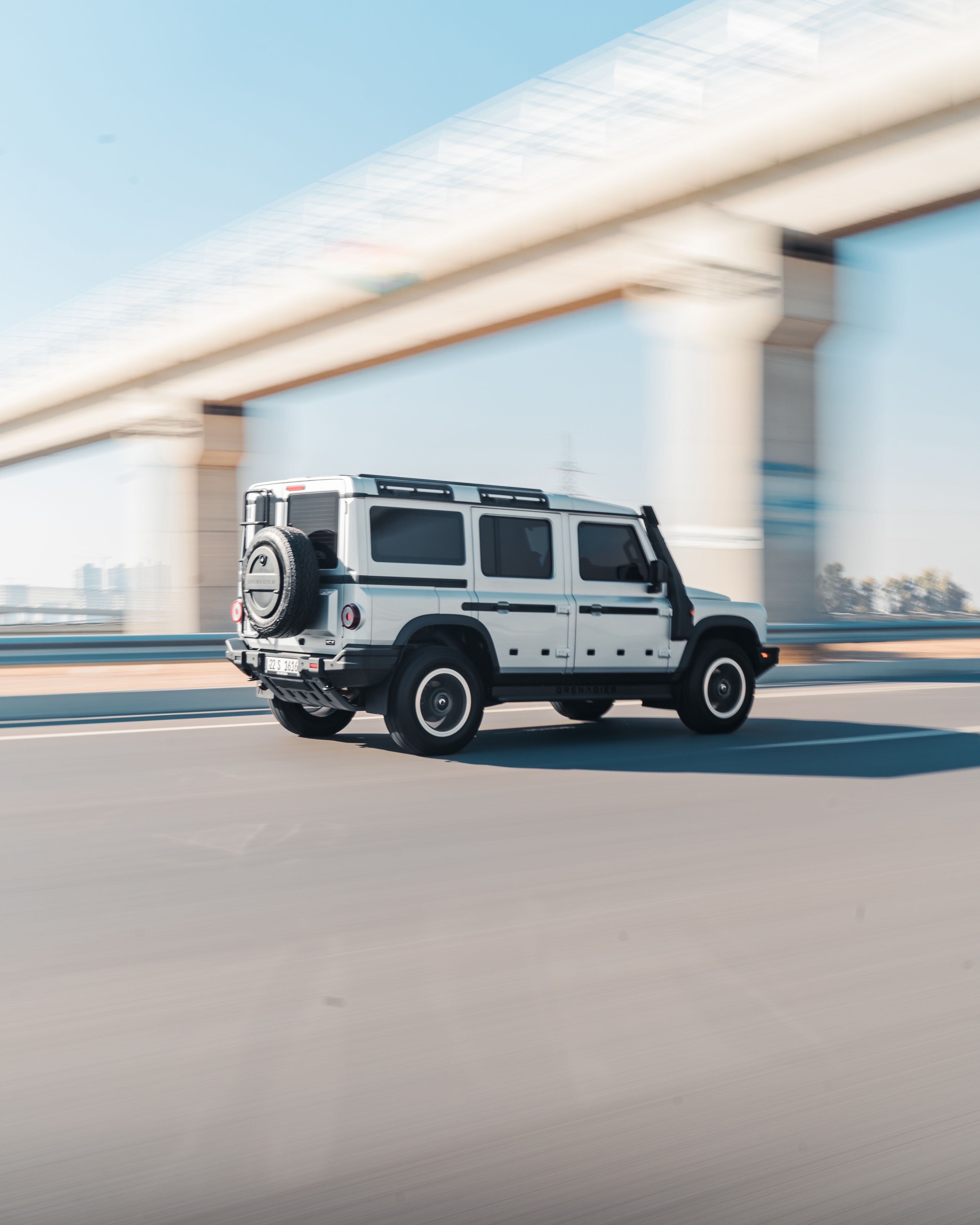 Sleek Off-Road SUV Cruising on Highway Bridge · Free Stock Photo