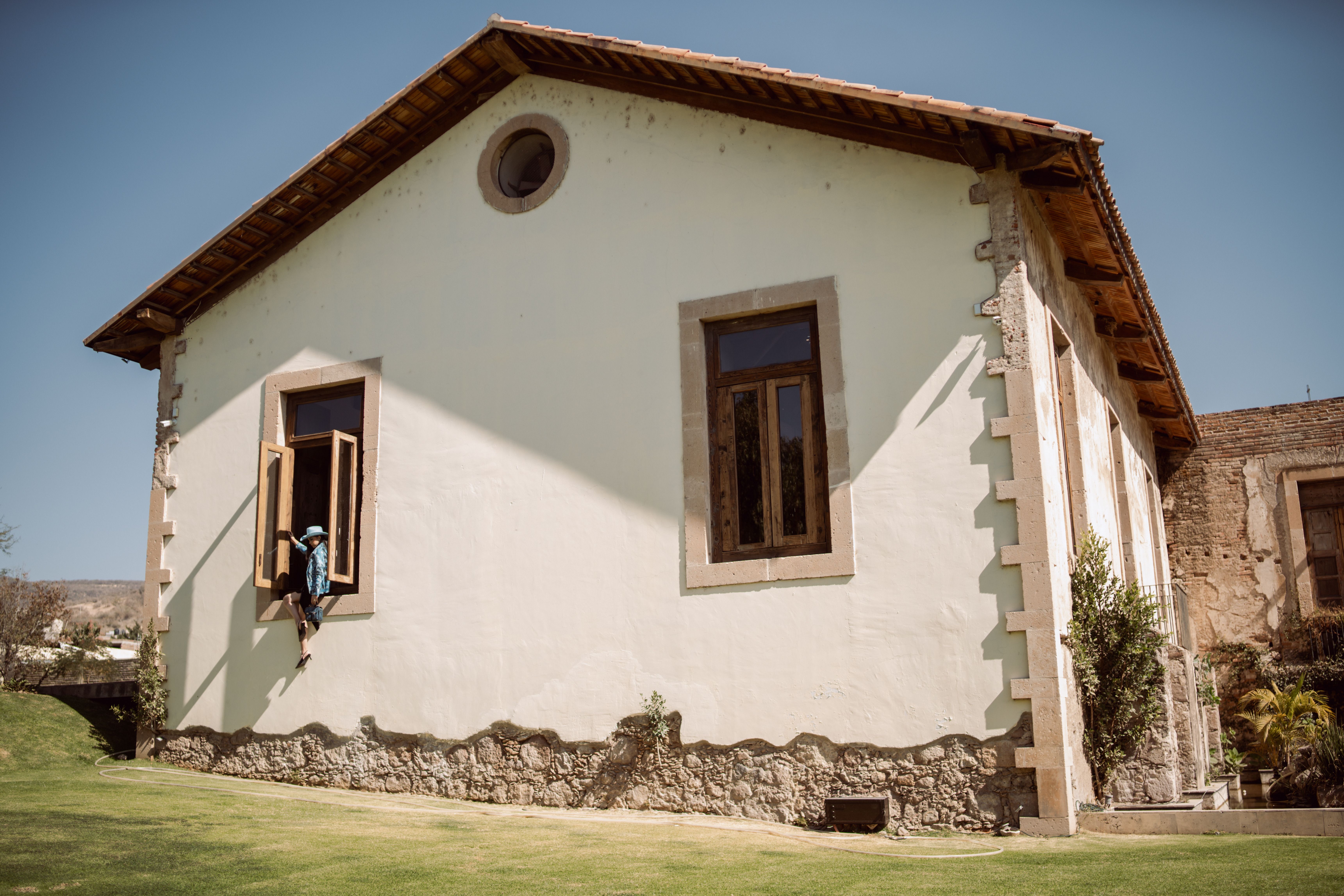 Person Climbing Out of Rustic Urban Building Window · Free Stock Photo