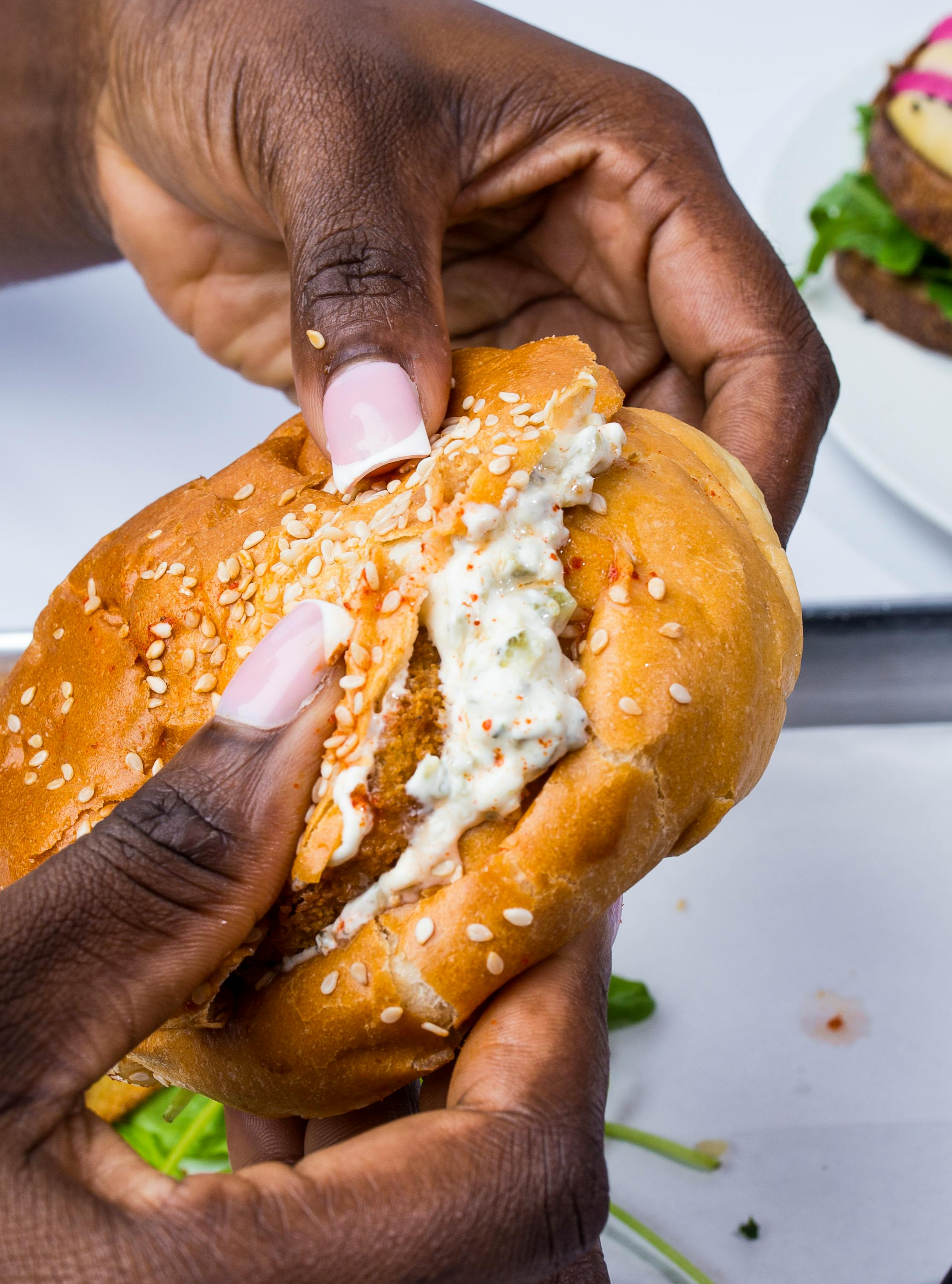 Close-up of Hands Holding a Sesame Seed Burger · Free Stock Photo