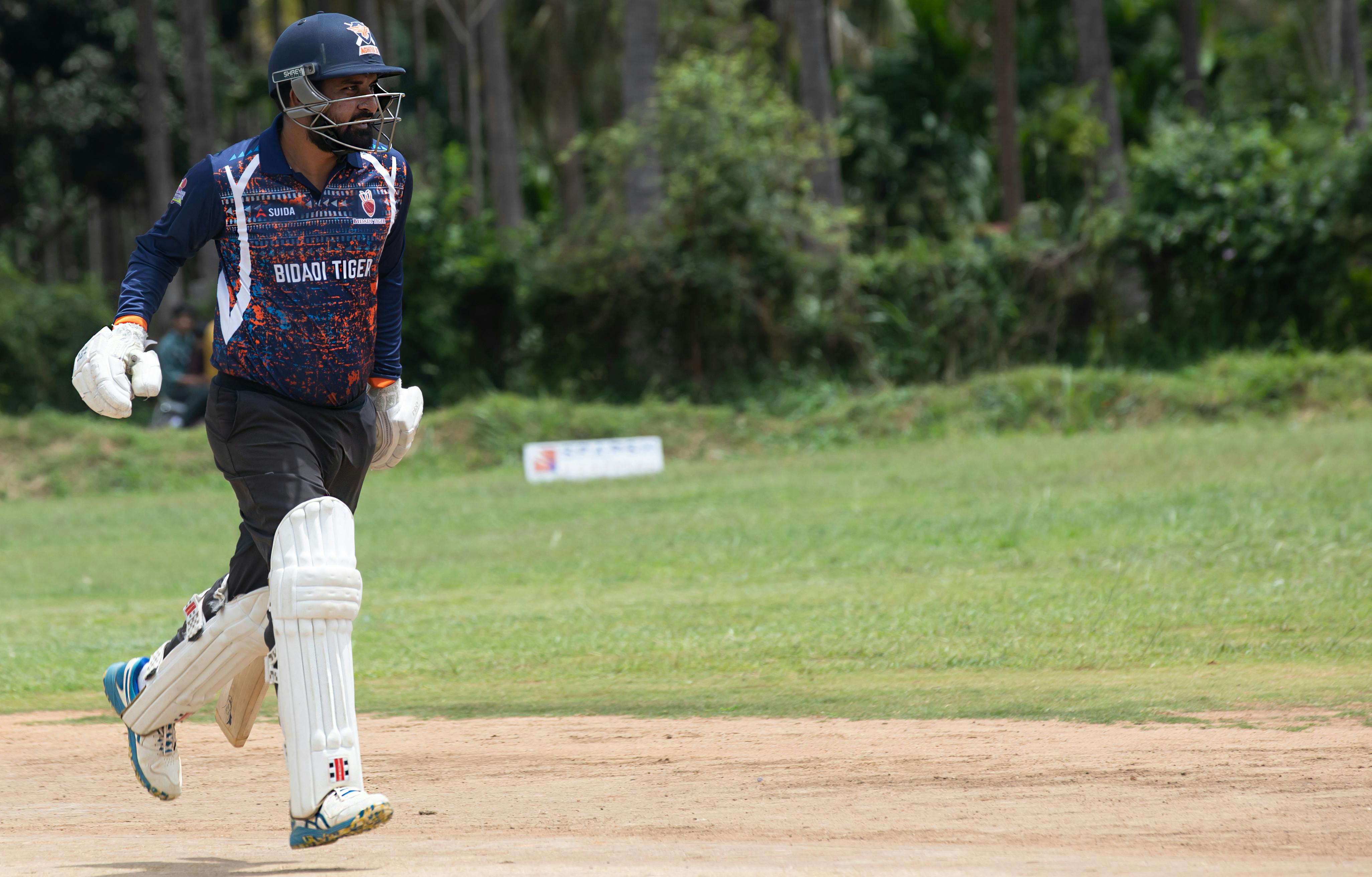 Cricketer Running on Natural Grass Field · Free Stock Photo